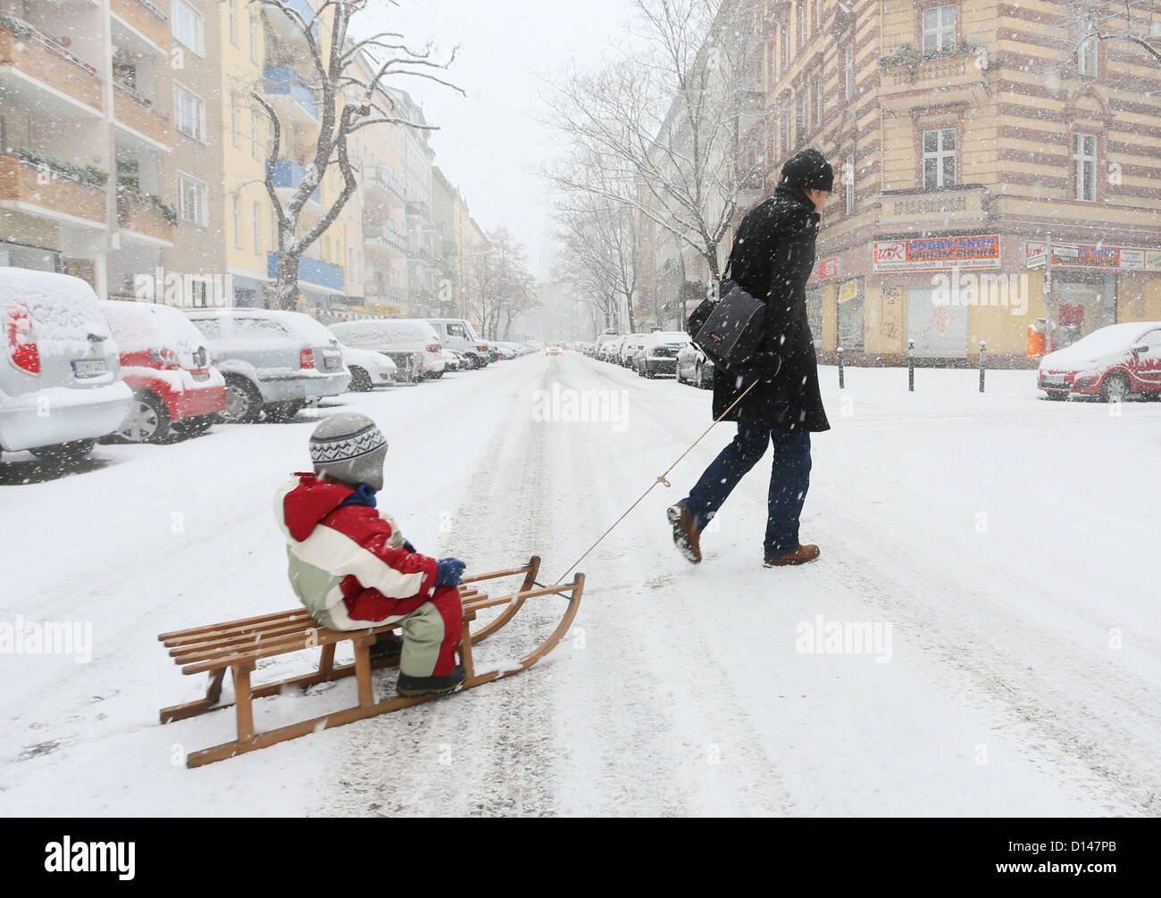 A father pulls his child to kindergarten on a sled in Berlin, Germany ...