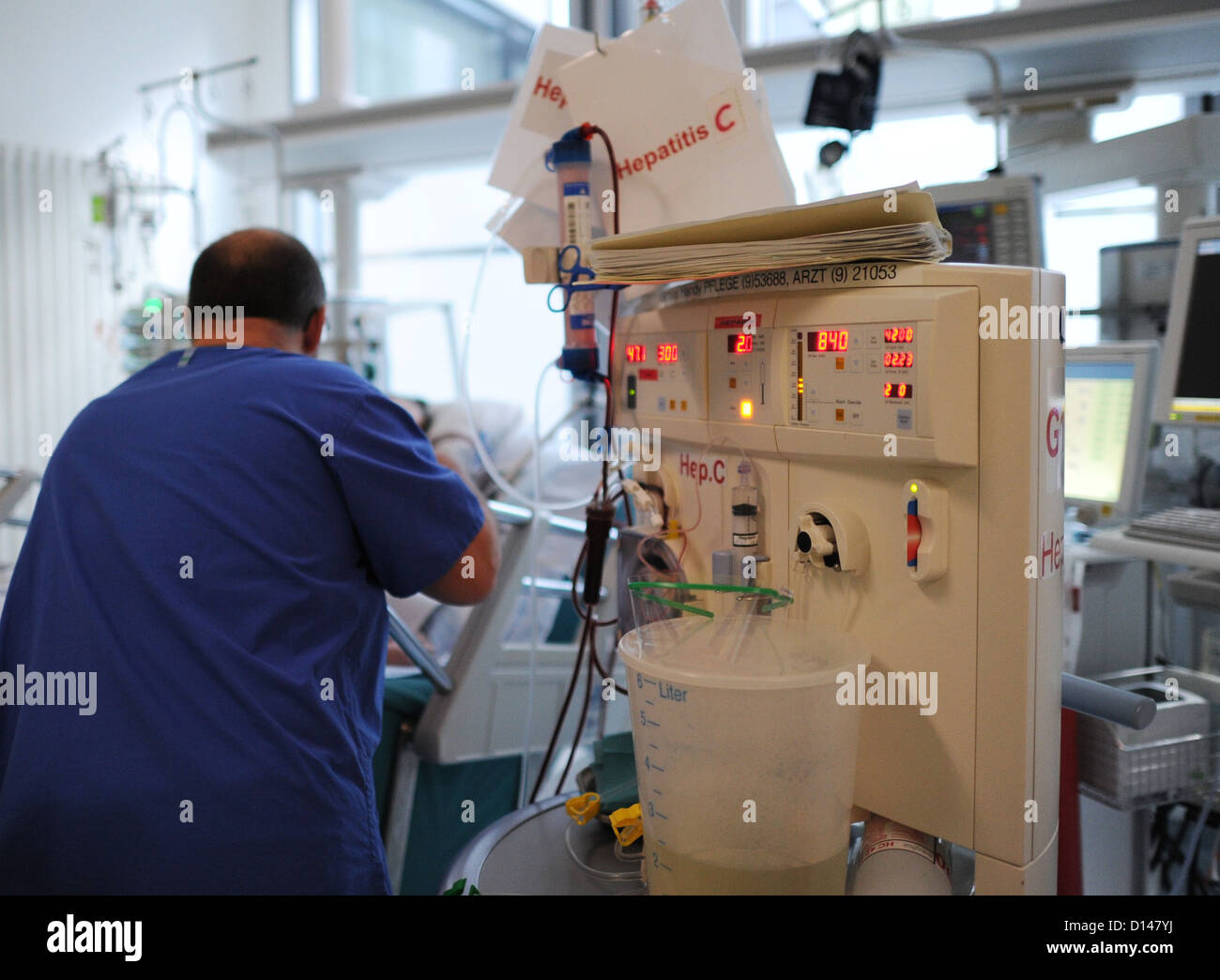 A male ICU nurse tends to a patient with hepatites C in the isolation ...
