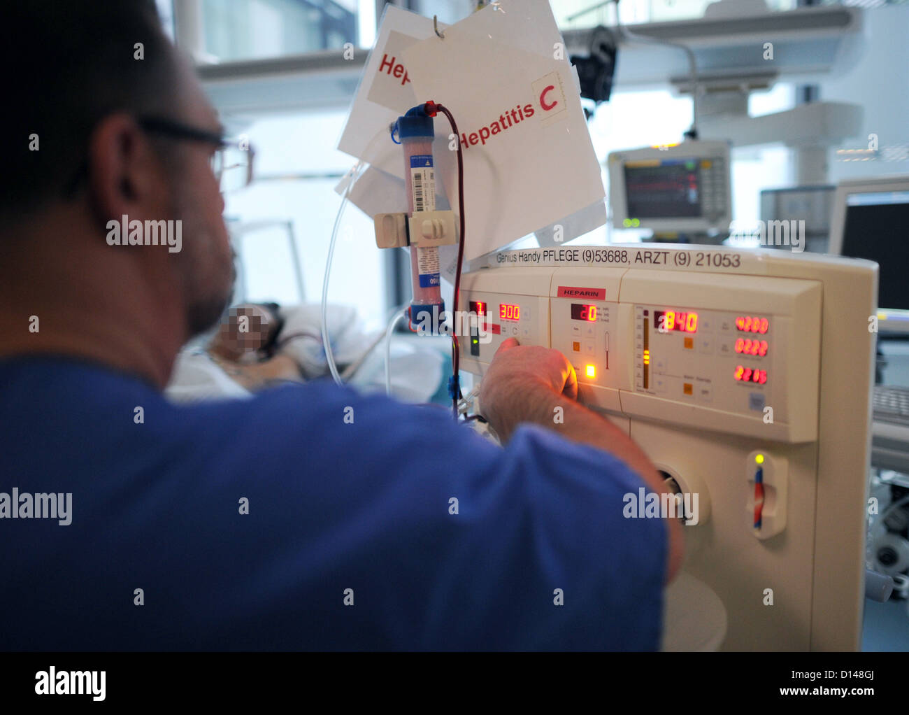 A male ICU nurse tends to a patient with hepatites C in the isolation ...