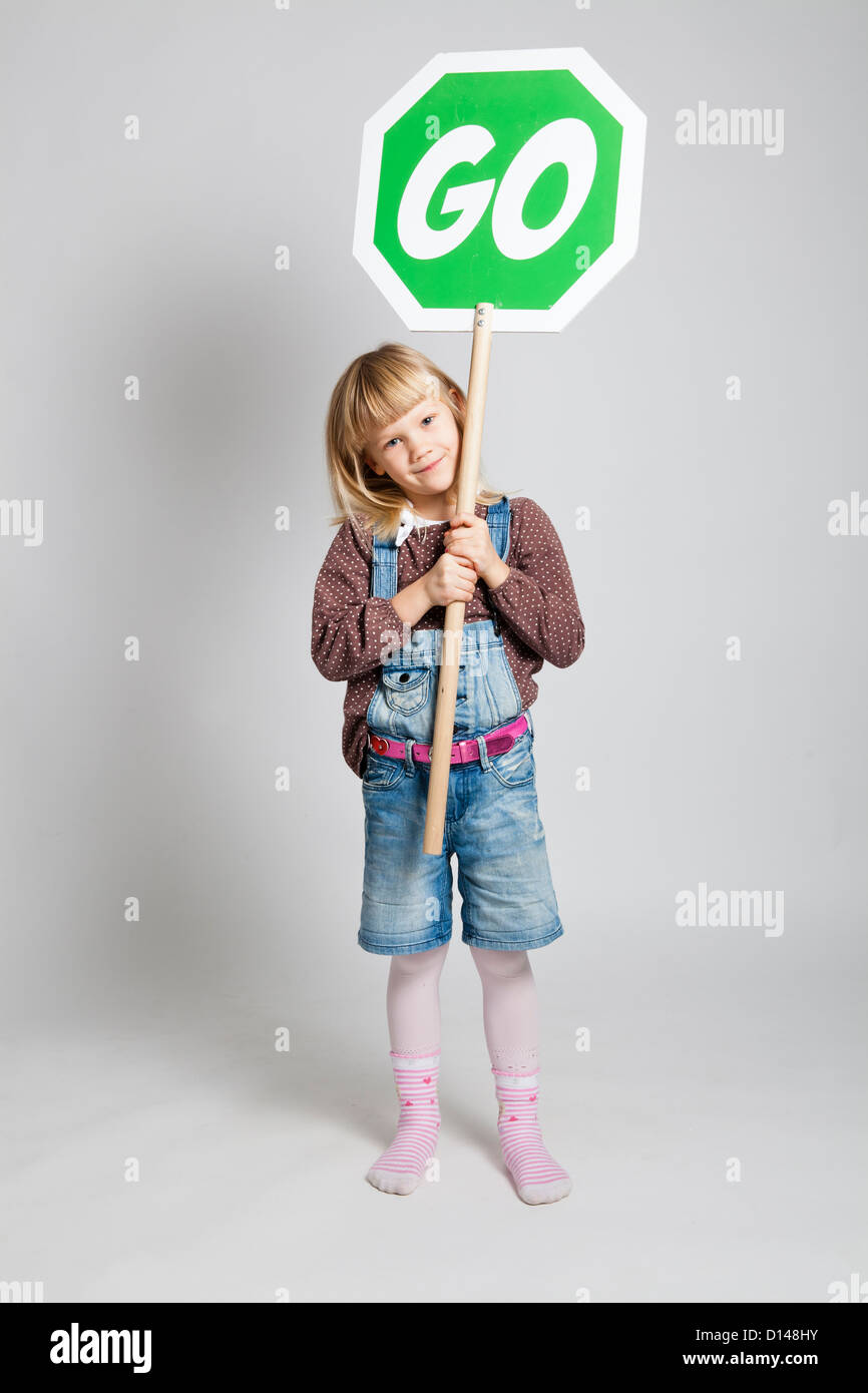 Studio portrait of young girl holding green go sign Stock Photo - Alamy
