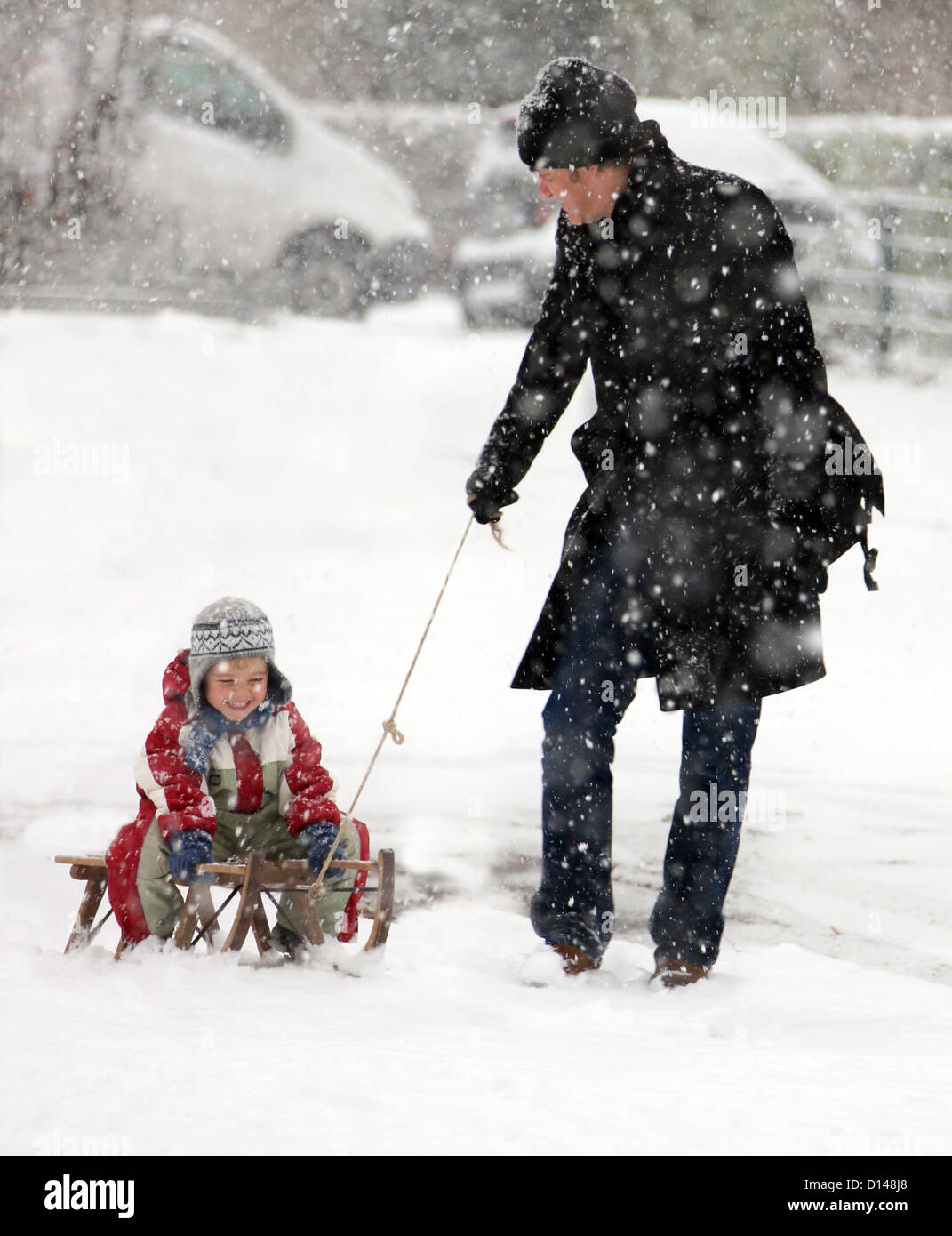 A father pulls his child to kindergarten on a sled in Berlin, Germany ...