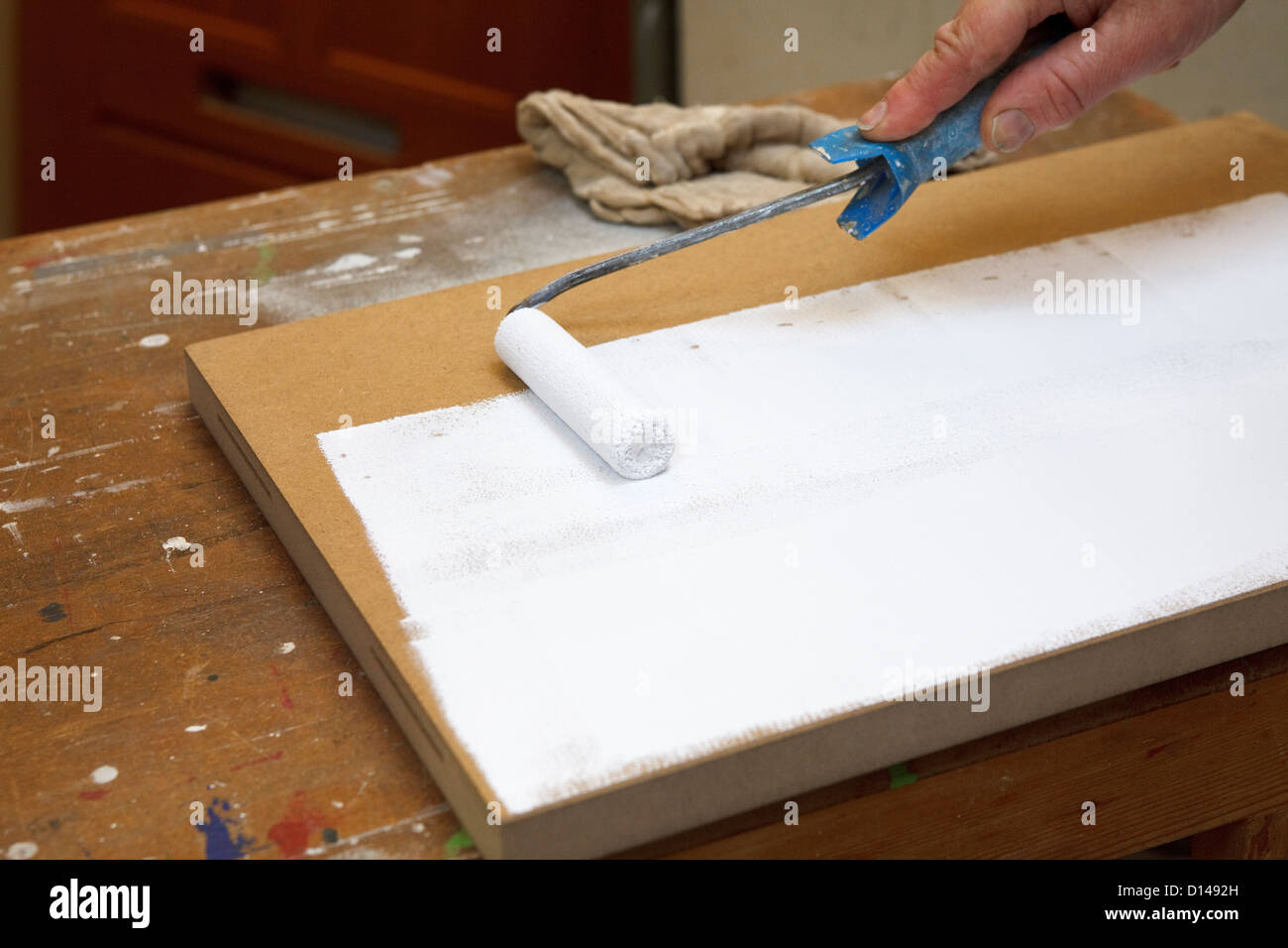 Painting a panel white with a roller Stock Photo - Alamy
