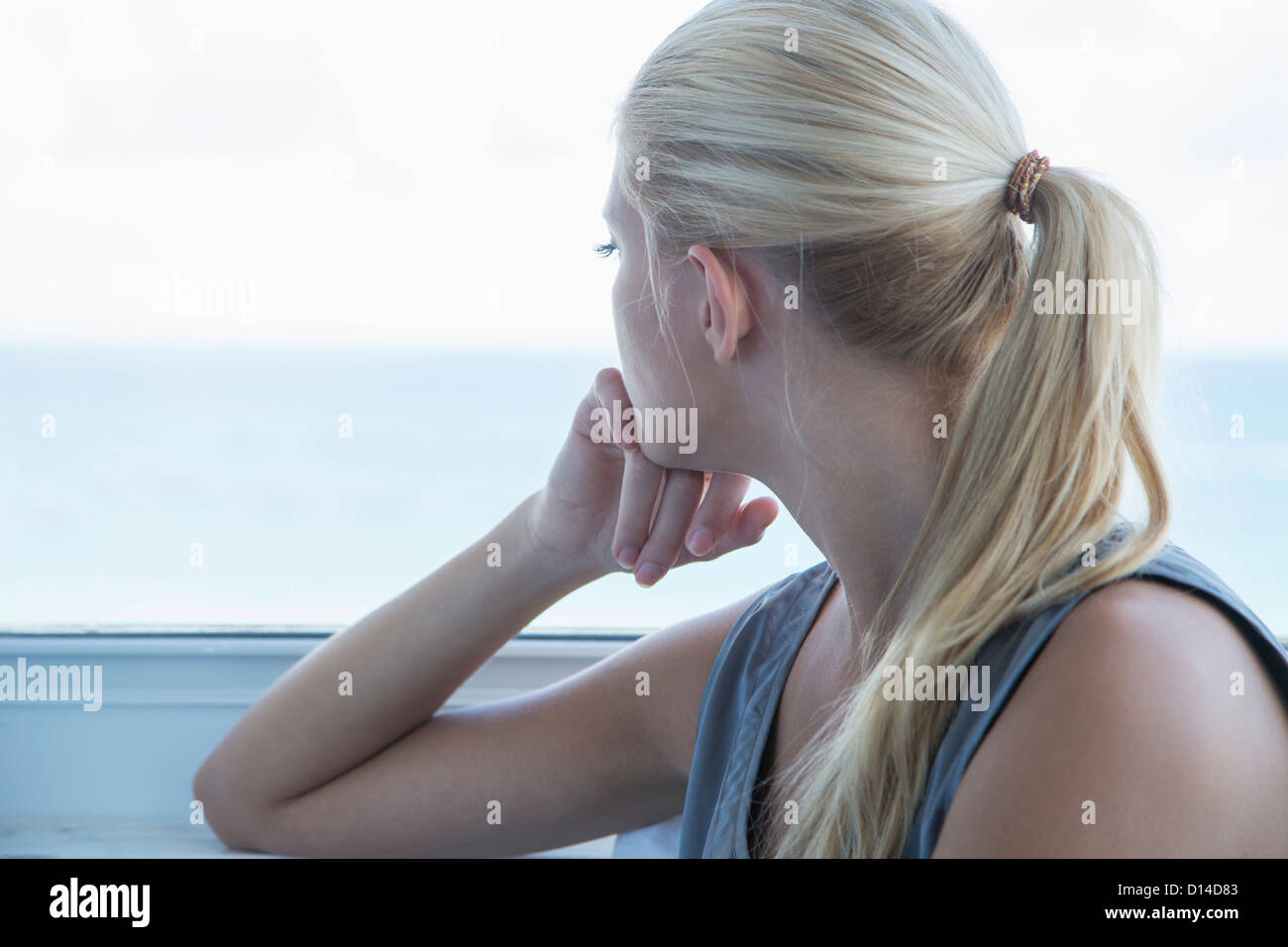 Woman looking out window Stock Photo - Alamy