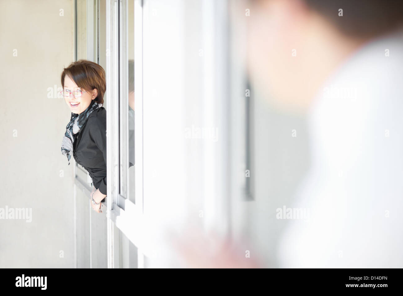 Businesswoman leaning out window Stock Photo - Alamy