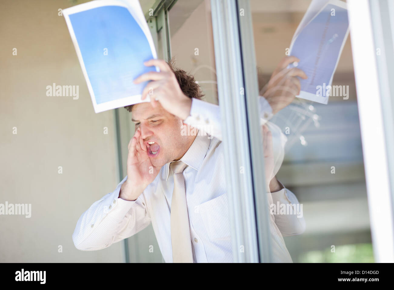 Businessman shouting from office window Stock Photo - Alamy