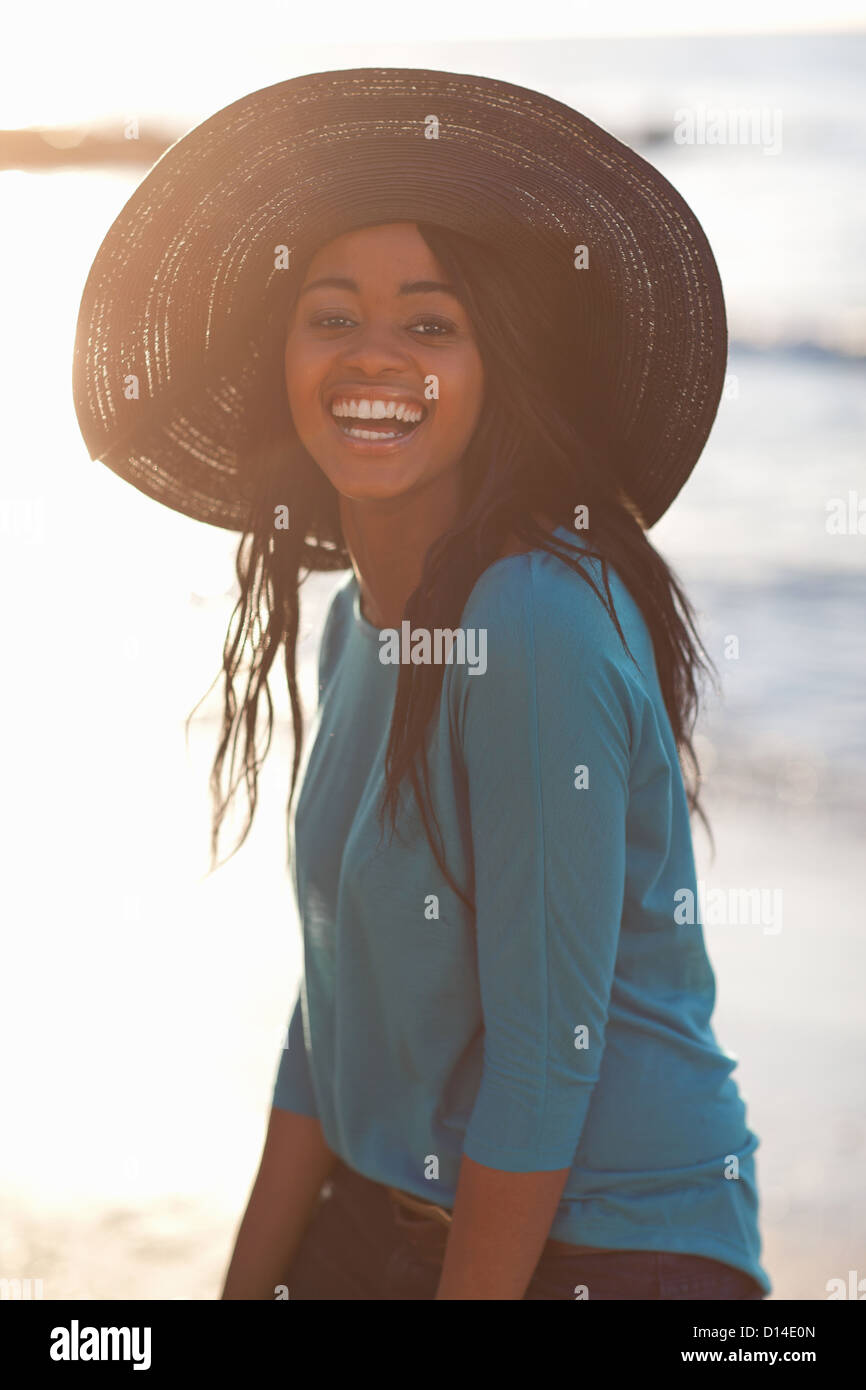 Smiling woman wearing sun hat on beach Stock Photo - Alamy