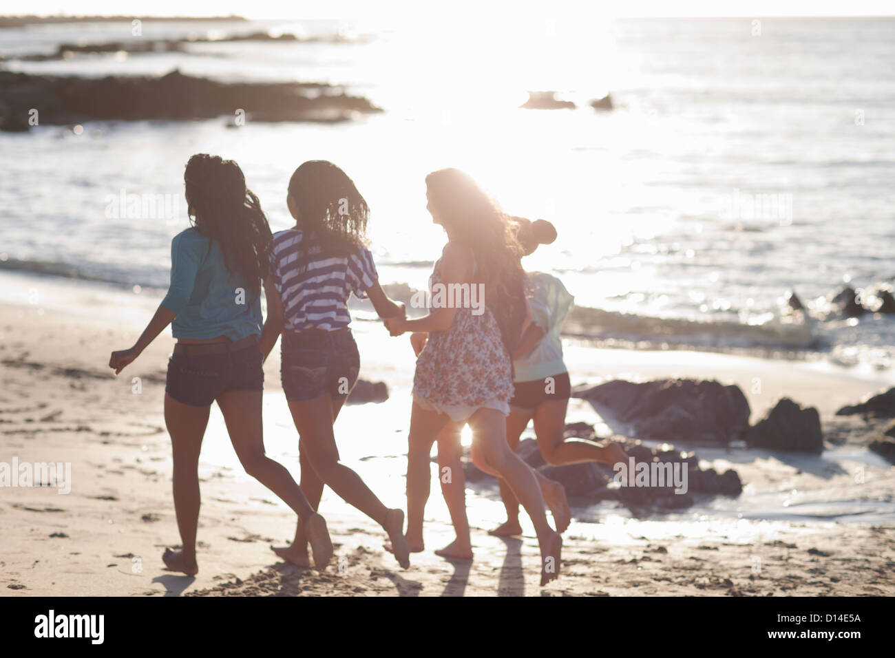 Women running together on beach Stock Photo - Alamy