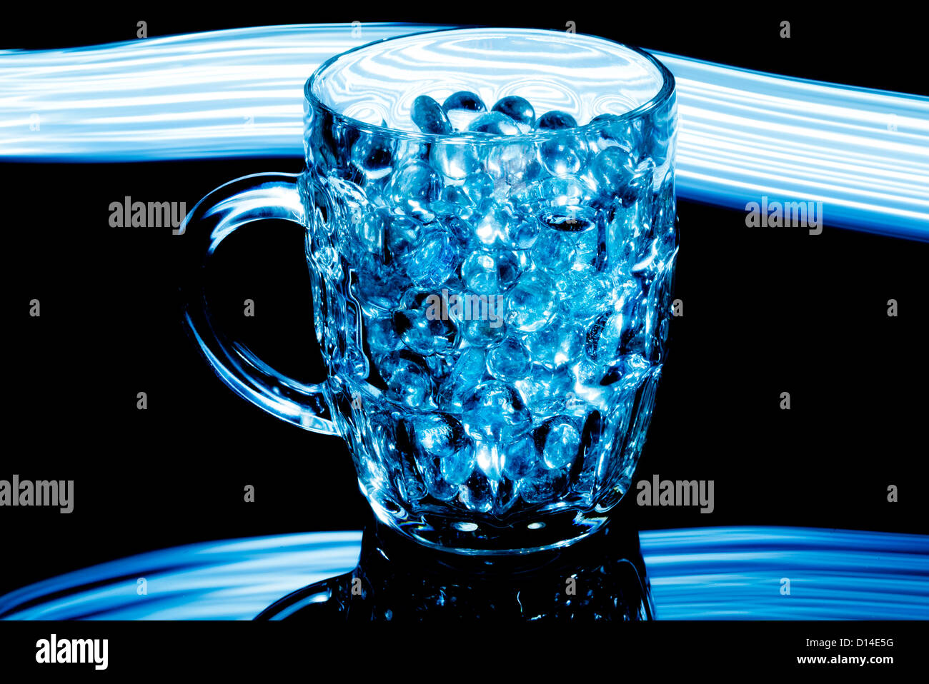 blue beer glass with ice cubes and streaks of light Stock Photo - Alamy