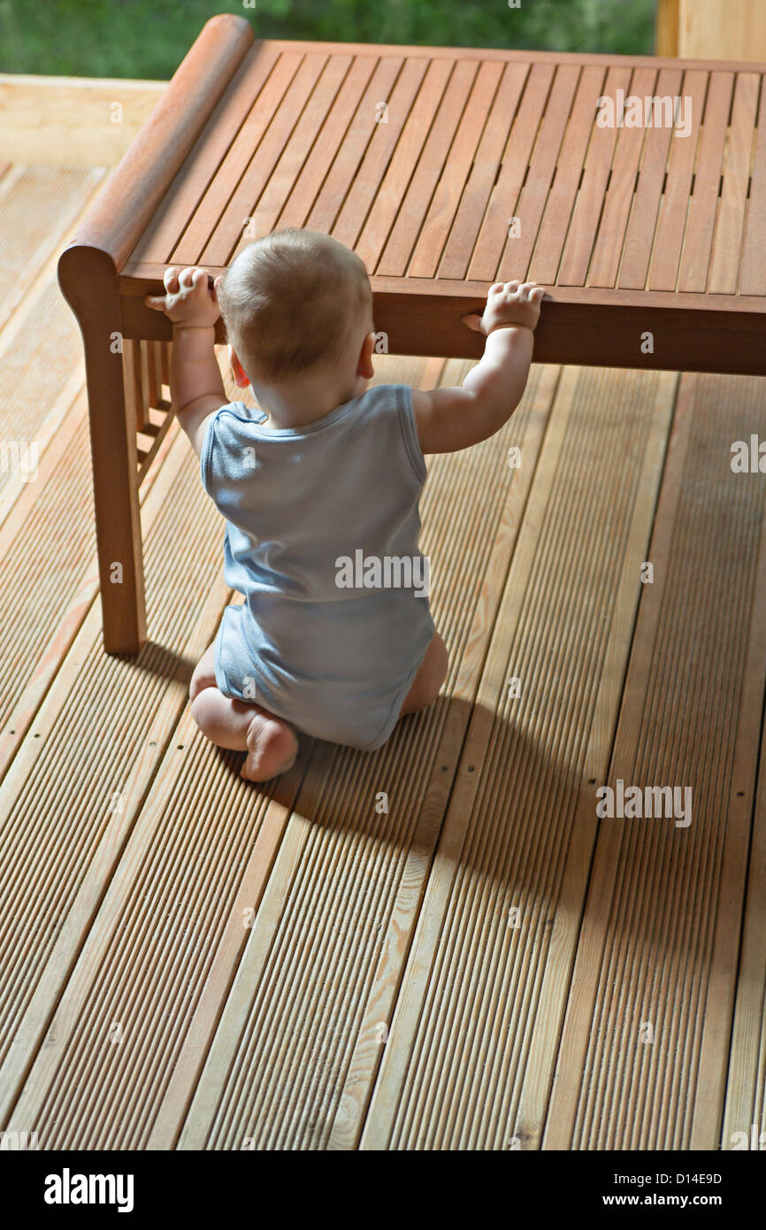 rear view of baby sitting in front of table Stock Photo - Alamy