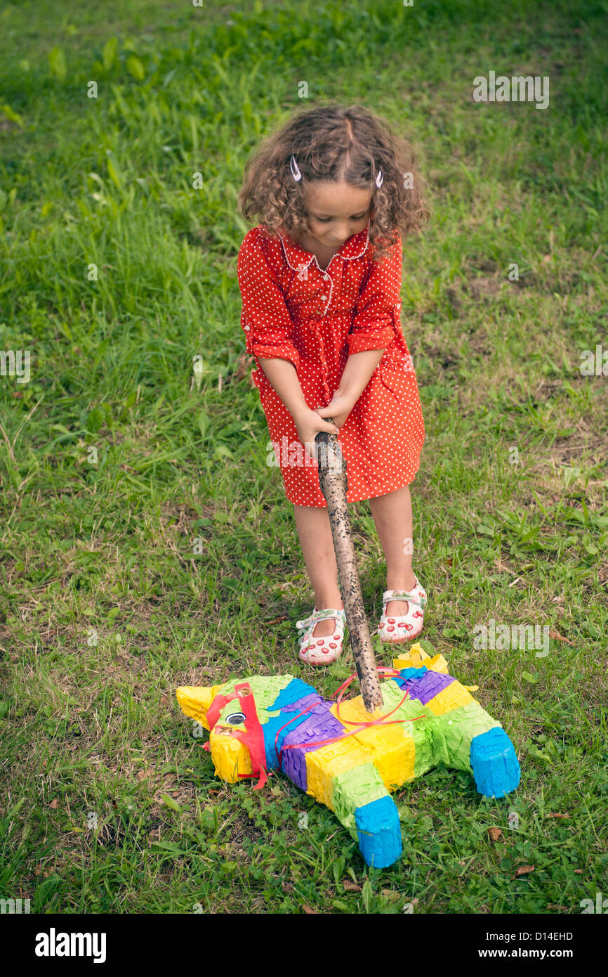 Girl opening pinata on ground at party Stock Photo - Alamy