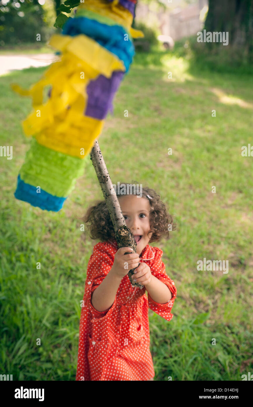 Girl swinging at pinata at party Stock Photo - Alamy