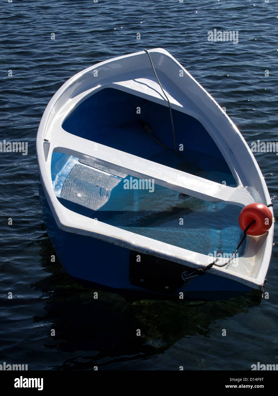 small blue plastic boat sinking after storm Stock Photo - Alamy