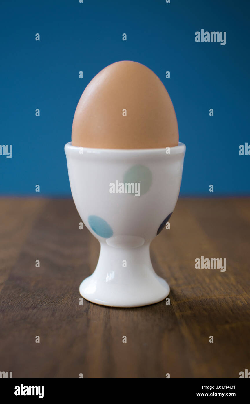 Egg in egg cup on table Stock Photo - Alamy