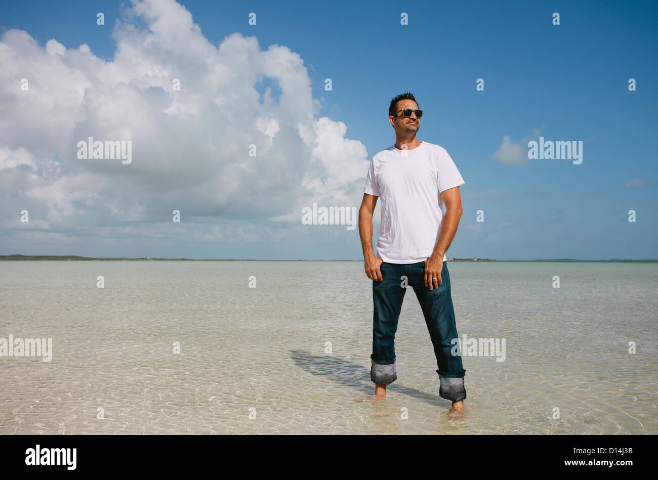 Man standing in water on tropical beach Stock Photo - Alamy