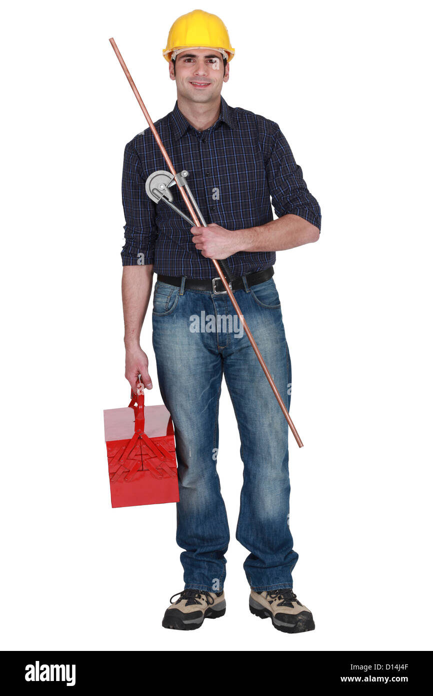 Plumber holding copper pipe and bending tool Stock Photo - Alamy
