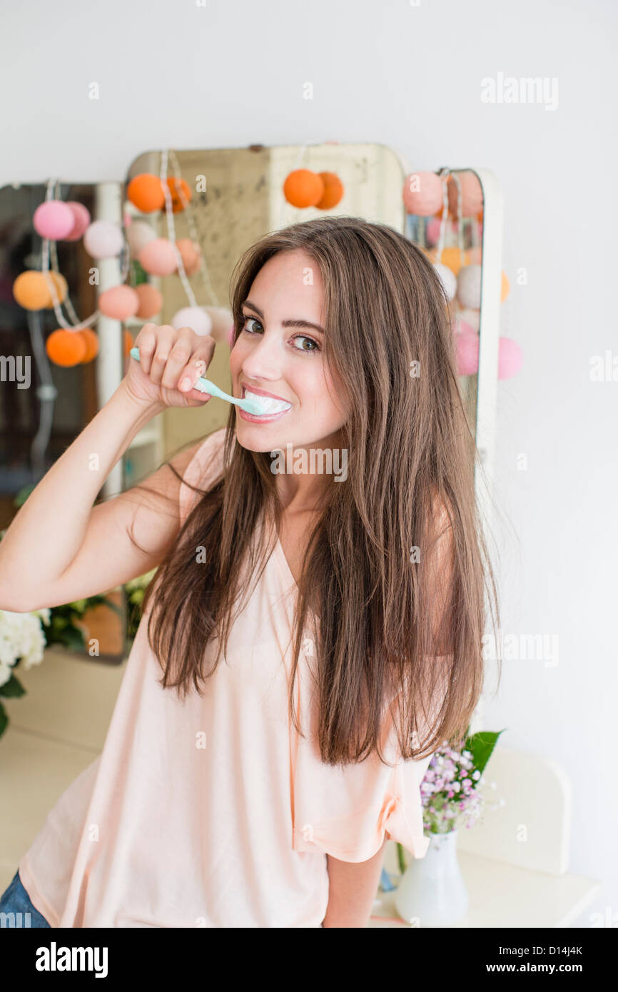 Smiling woman brushing her teeth Stock Photo - Alamy