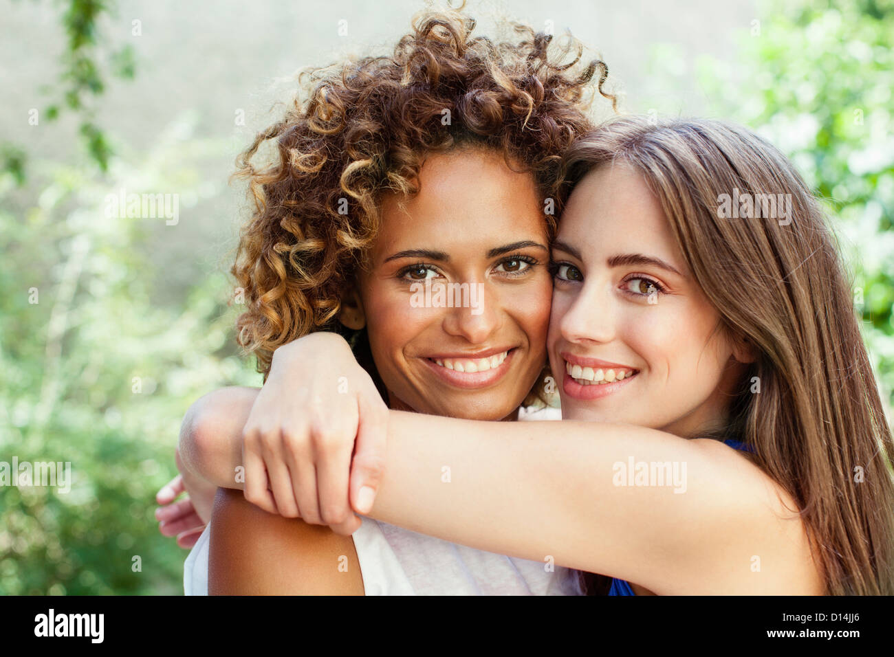 Smiling women hugging outdoors Stock Photo - Alamy