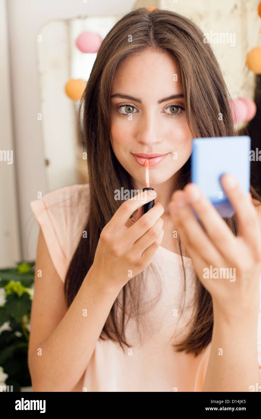 Woman applying make up in mirror Stock Photo - Alamy