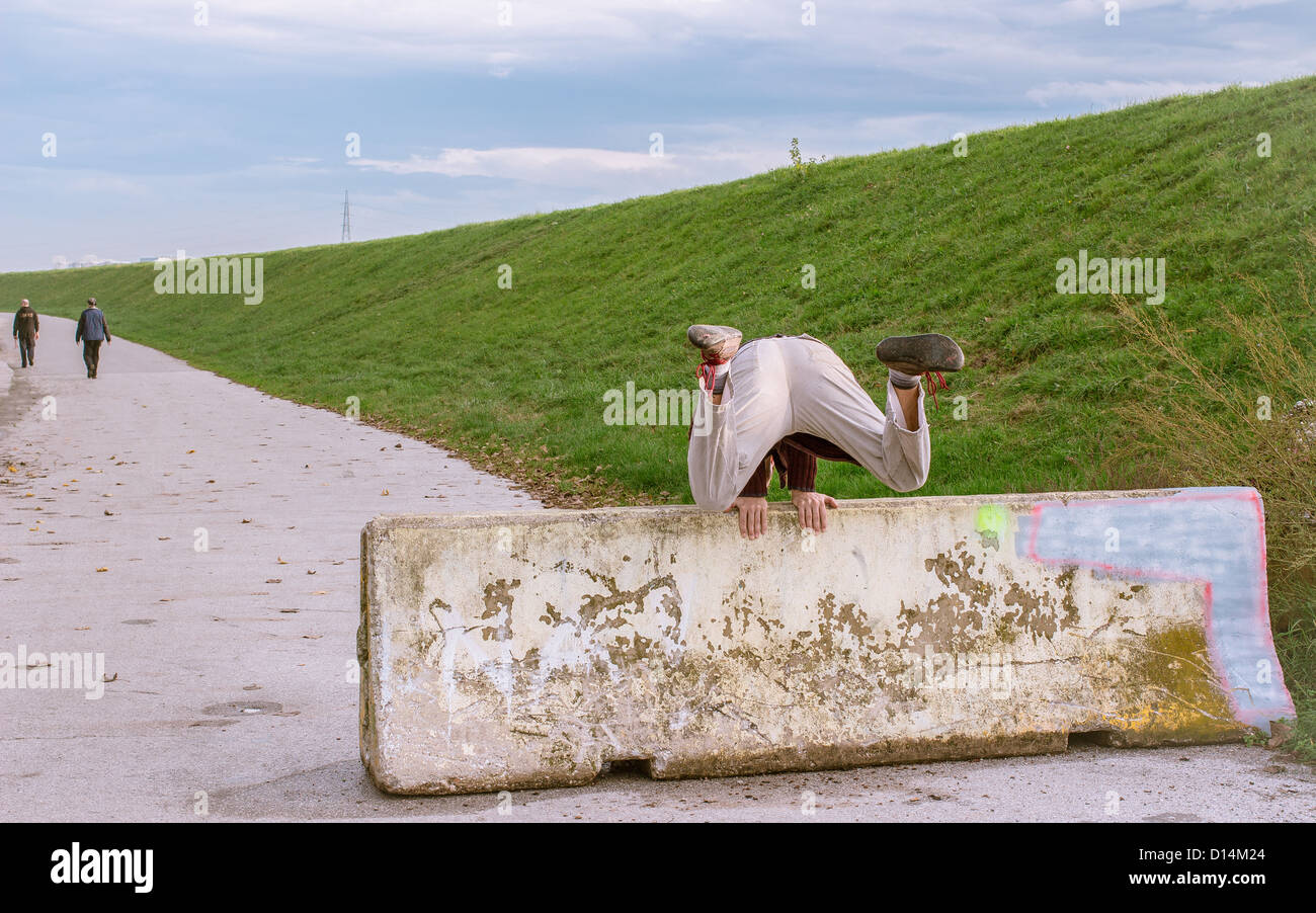 Man doing parkour, jumping over a block, supporting himself with hands ...