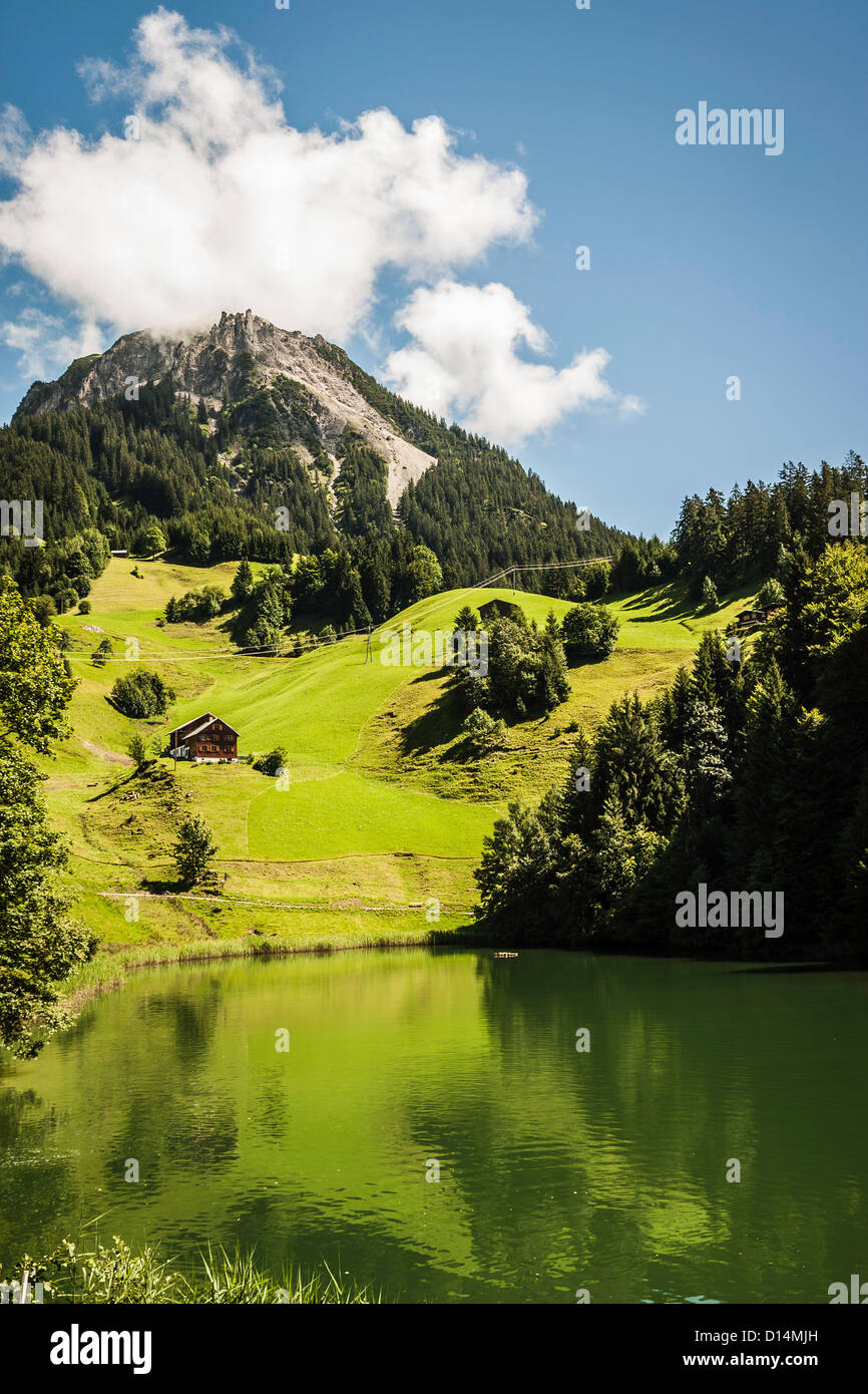 Grassy hillside by still rural lake Stock Photo - Alamy