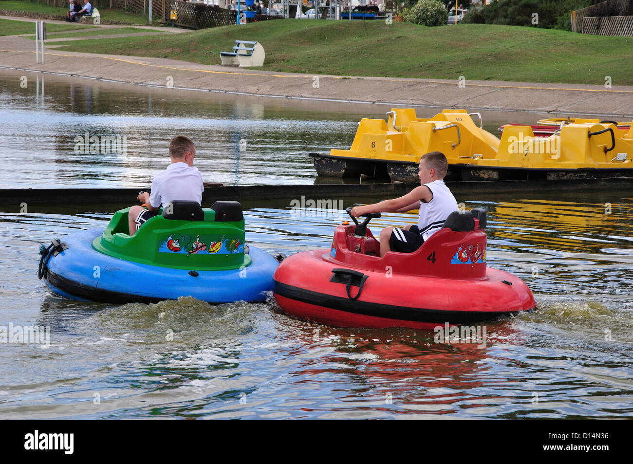 Two boys having fun on dodgem boats UK Stock Photo - Alamy