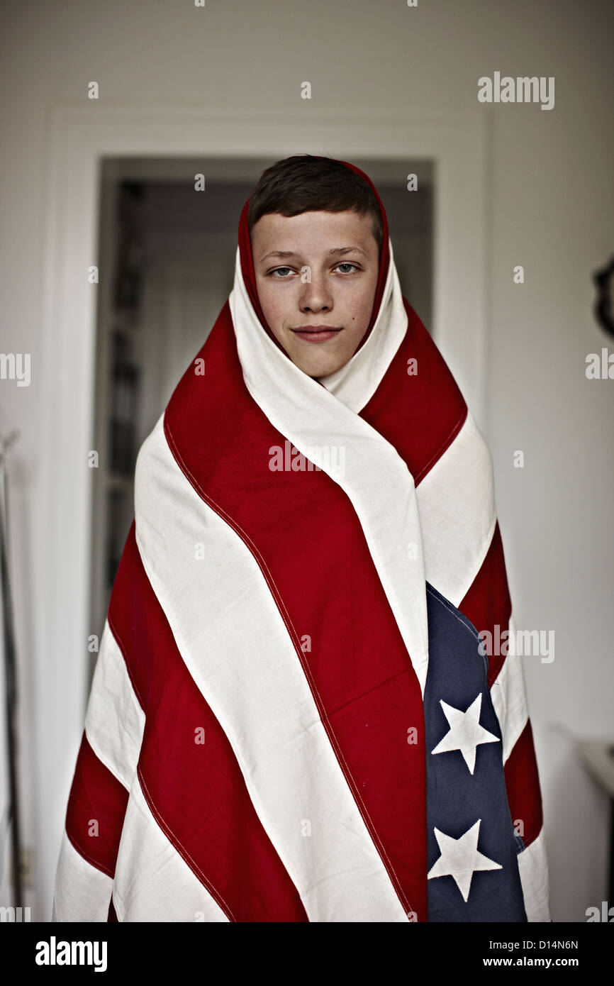 Boy wrapped in American flag indoors Stock Photo - Alamy