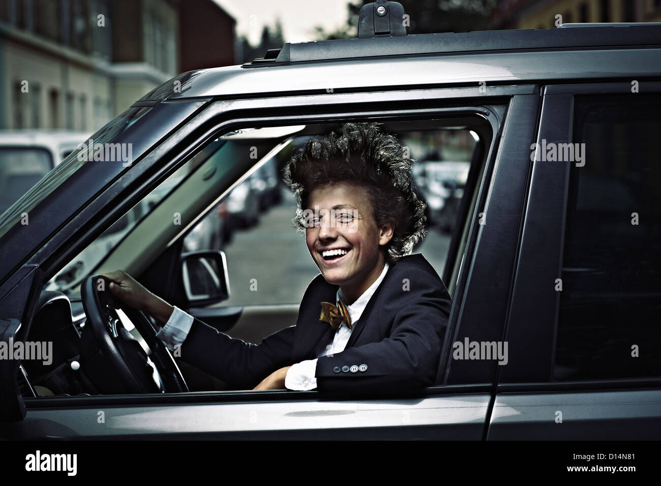 Teenage boy driving on city street Stock Photo - Alamy