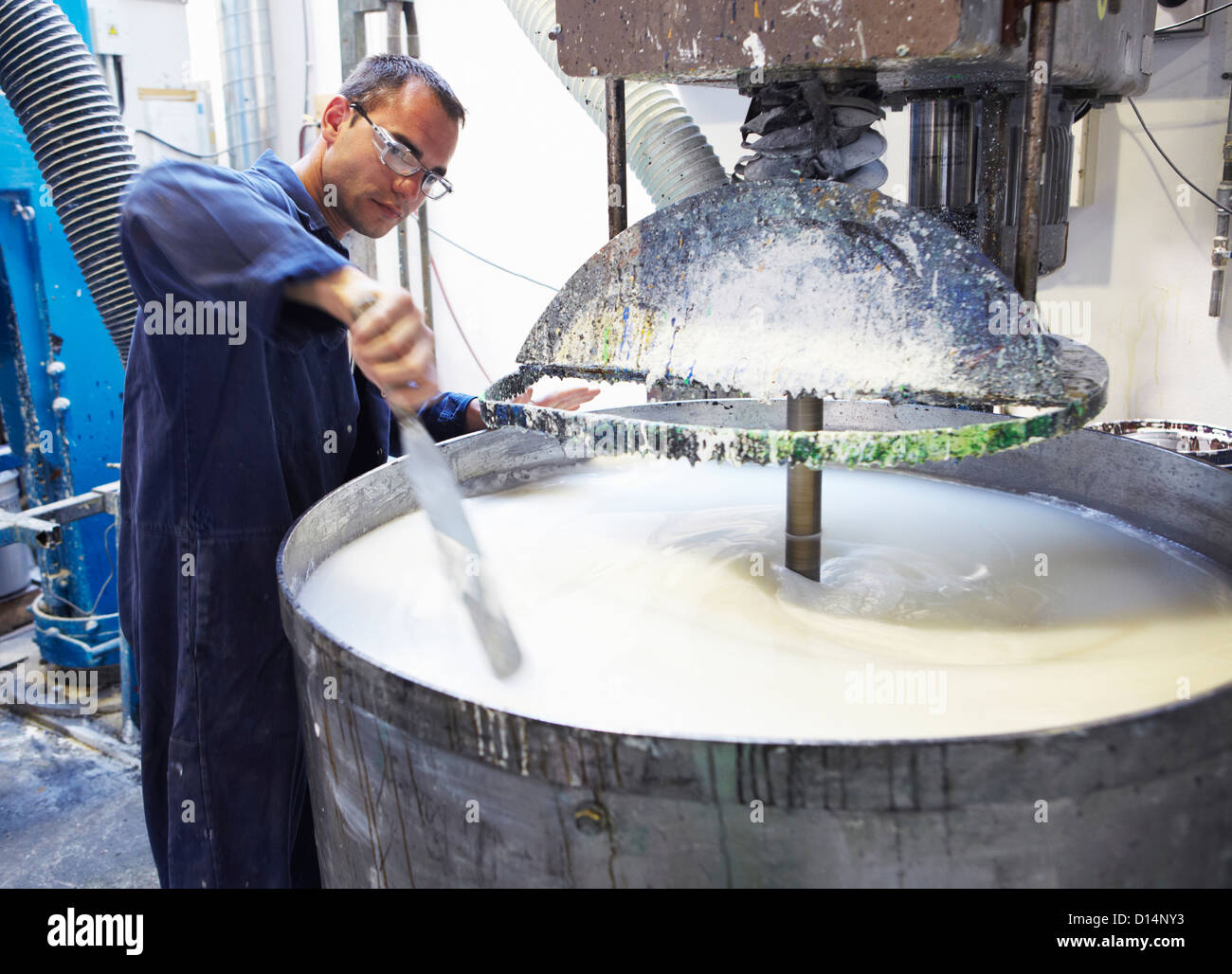 Worker stirring vat of liquid in factory Stock Photo - Alamy