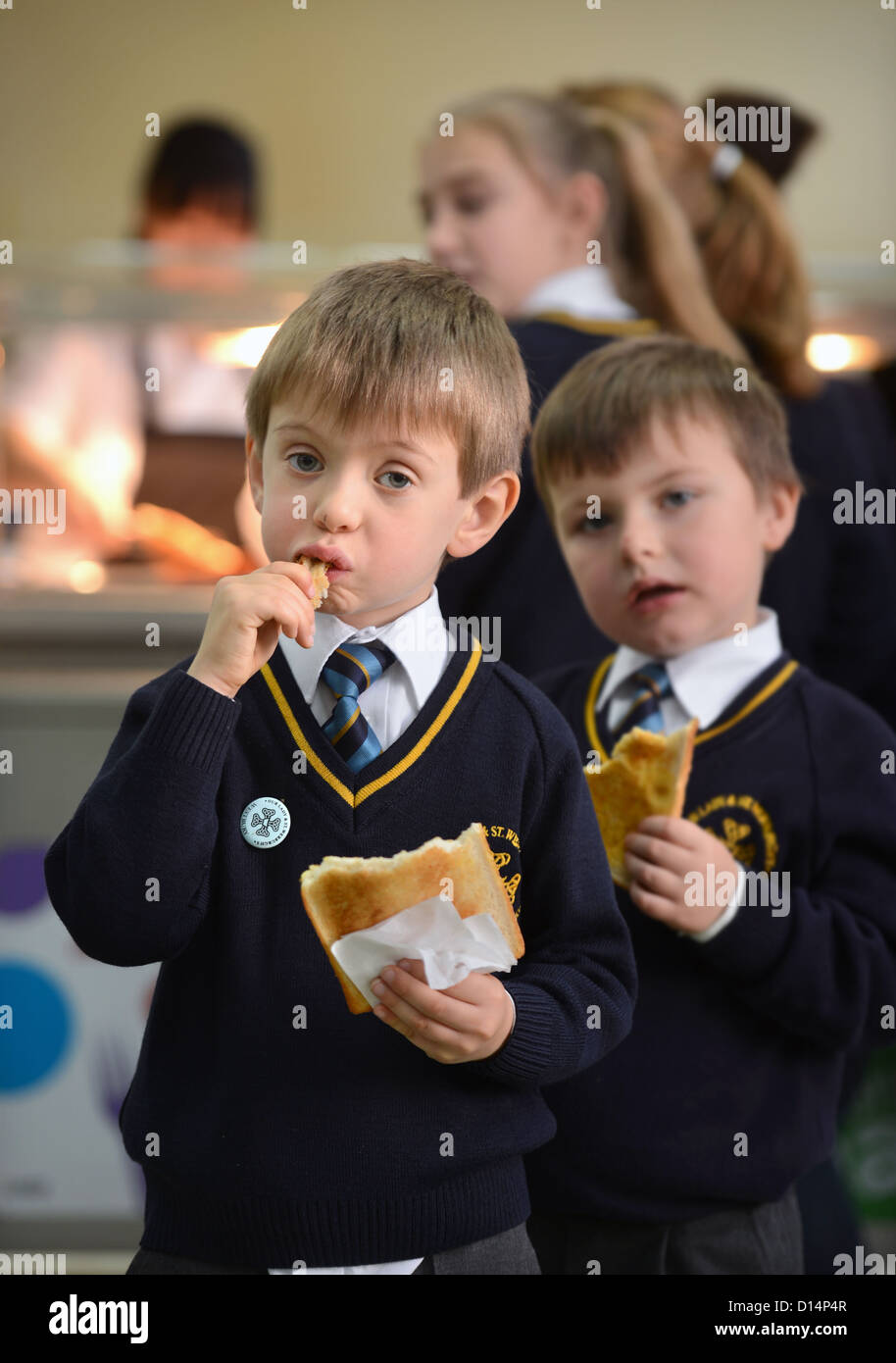 A schoolboy eating toast after morning assembly at Our Lady & St ...