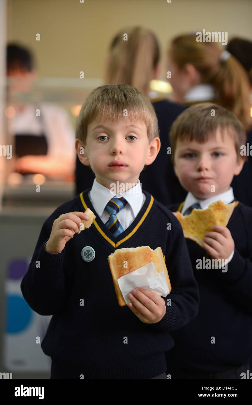 A schoolboy eating toast after morning assembly at Our Lady & St ...
