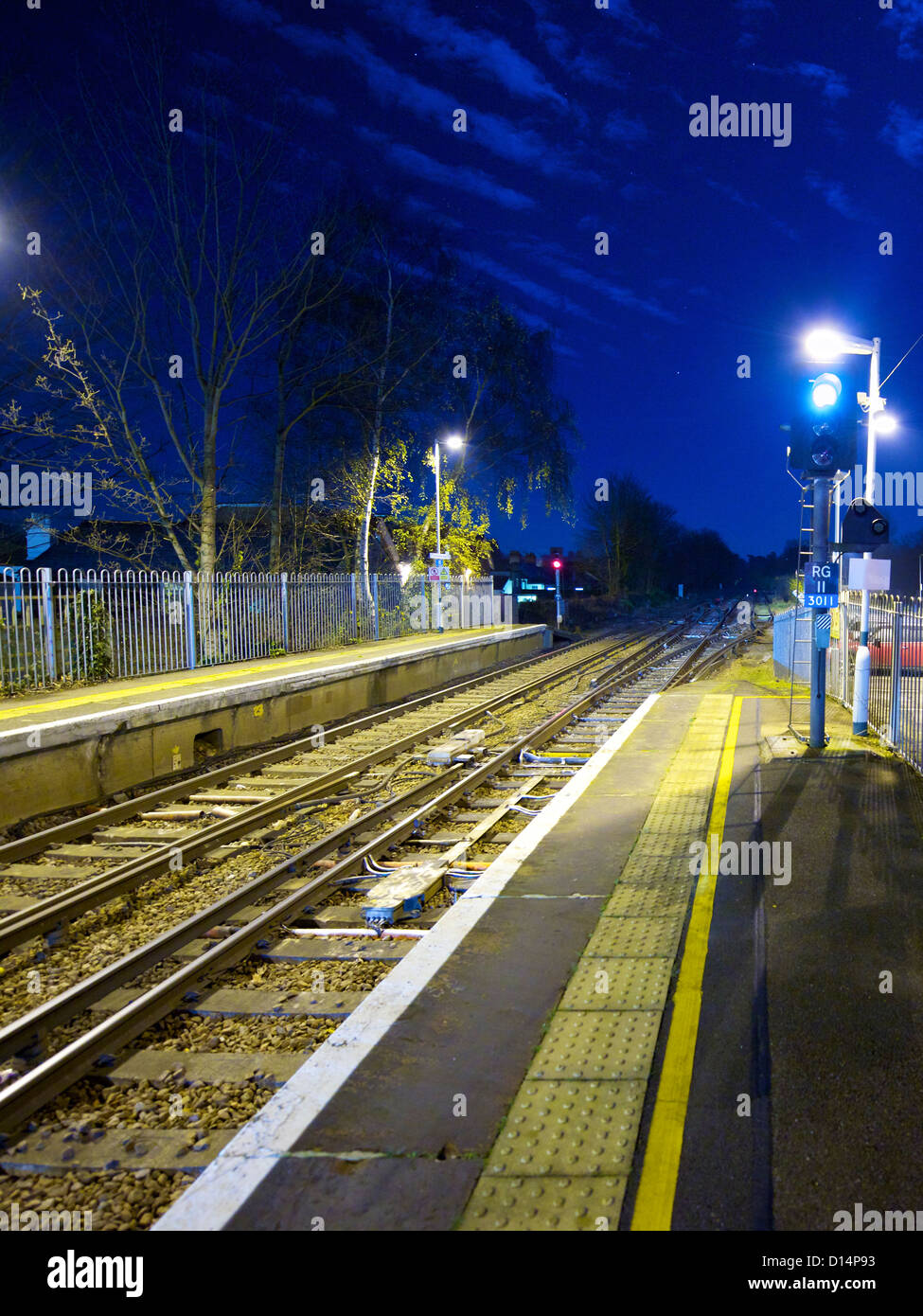Under a starlit and moonlit December night sky, an empty railway ...