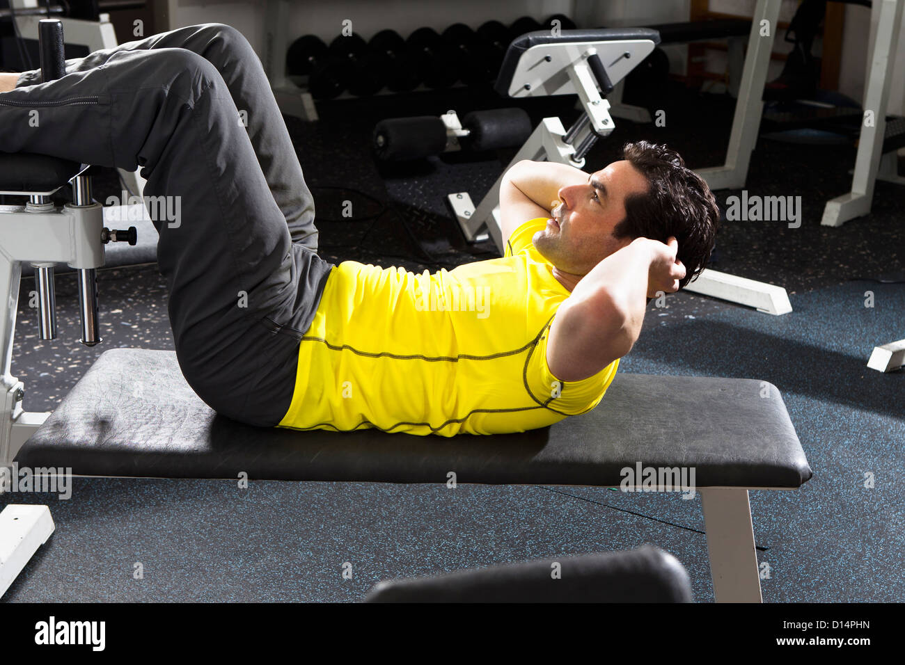 Man using exercise equipment at gym Stock Photo - Alamy