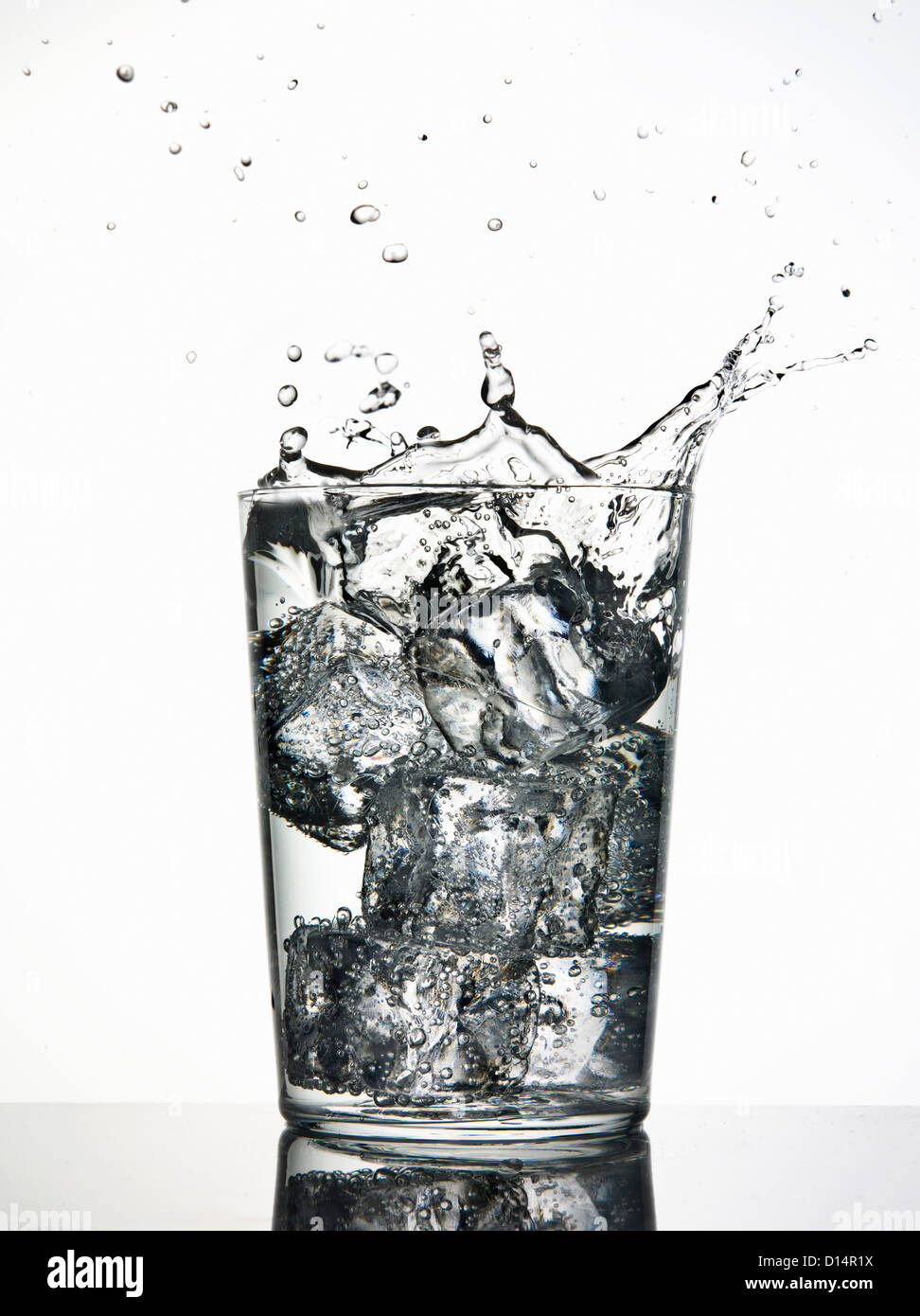 Ice cubes splashing into fizzy drink Stock Photo - Alamy