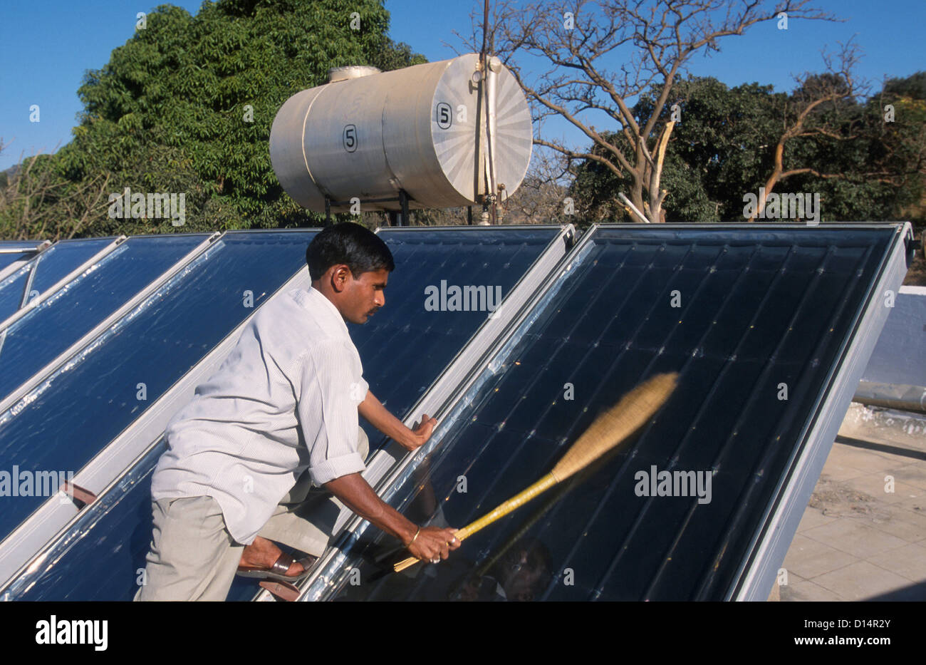 India Rajasthan, man clean solar collector in Brahma Kumari Ashram in ...