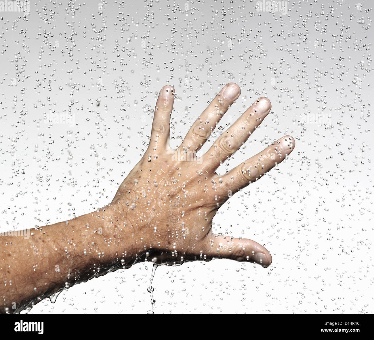 Hand thrust into falling water drops Stock Photo - Alamy