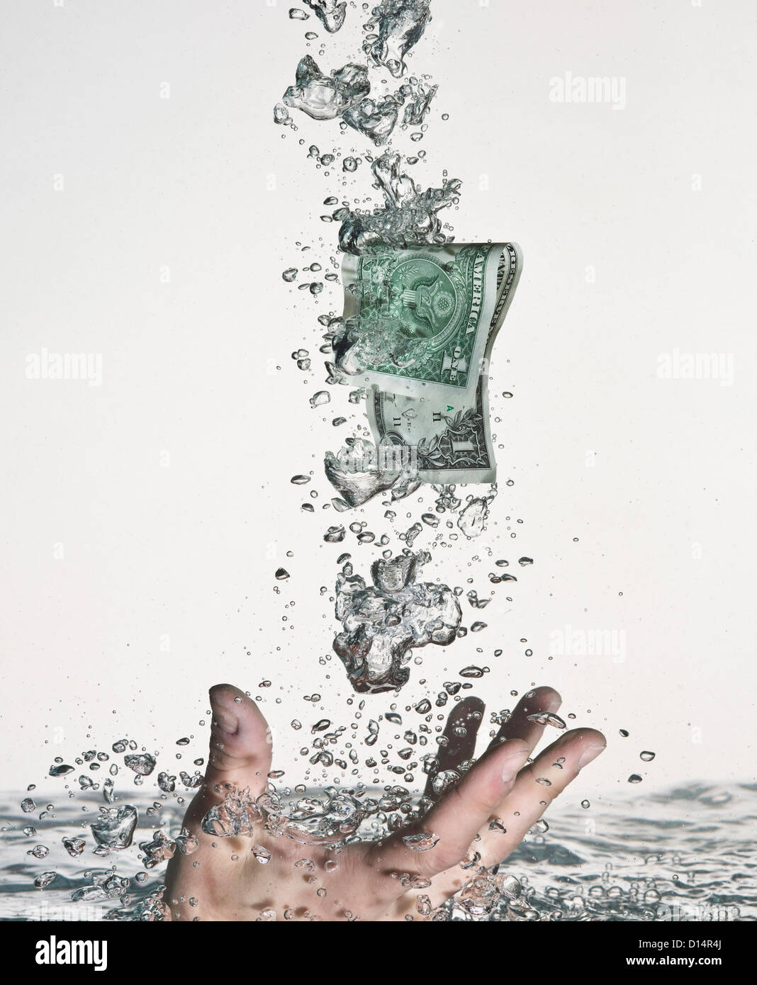 Hand grasping dollar bill in water Stock Photo - Alamy
