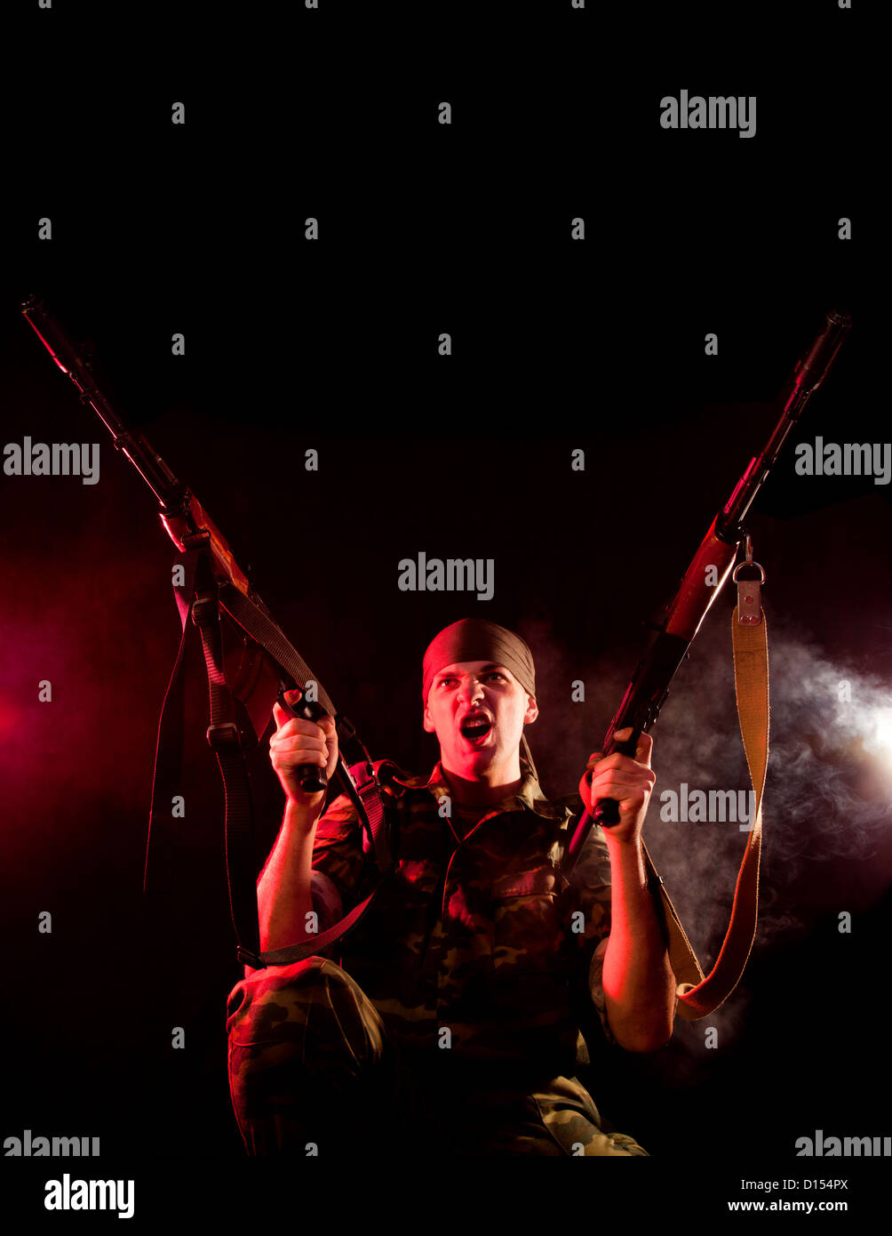 Screaming soldier with two guns, focus on face Stock Photo - Alamy