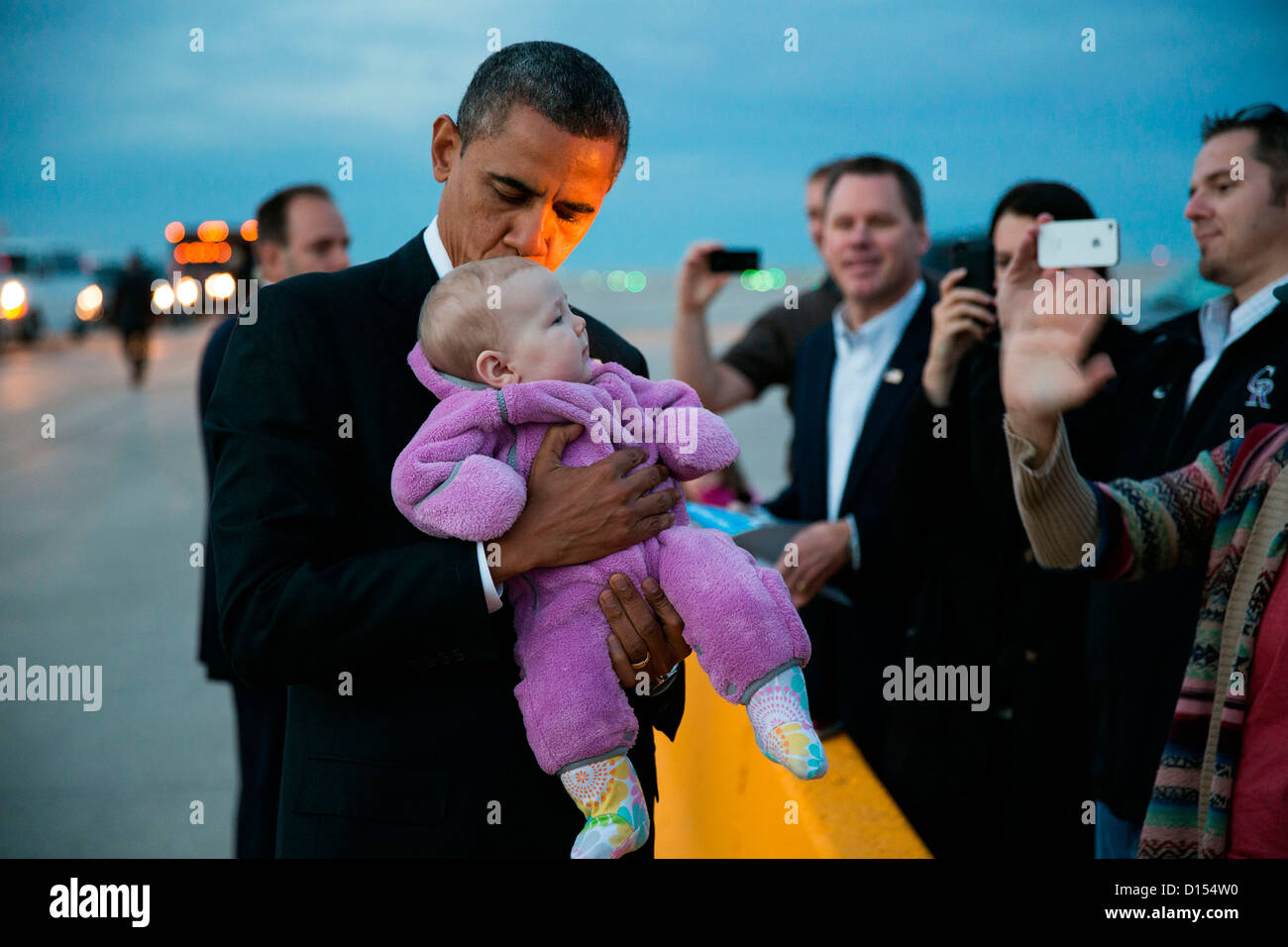 US President Barack Obama kisses a baby on the tarmac following his ...