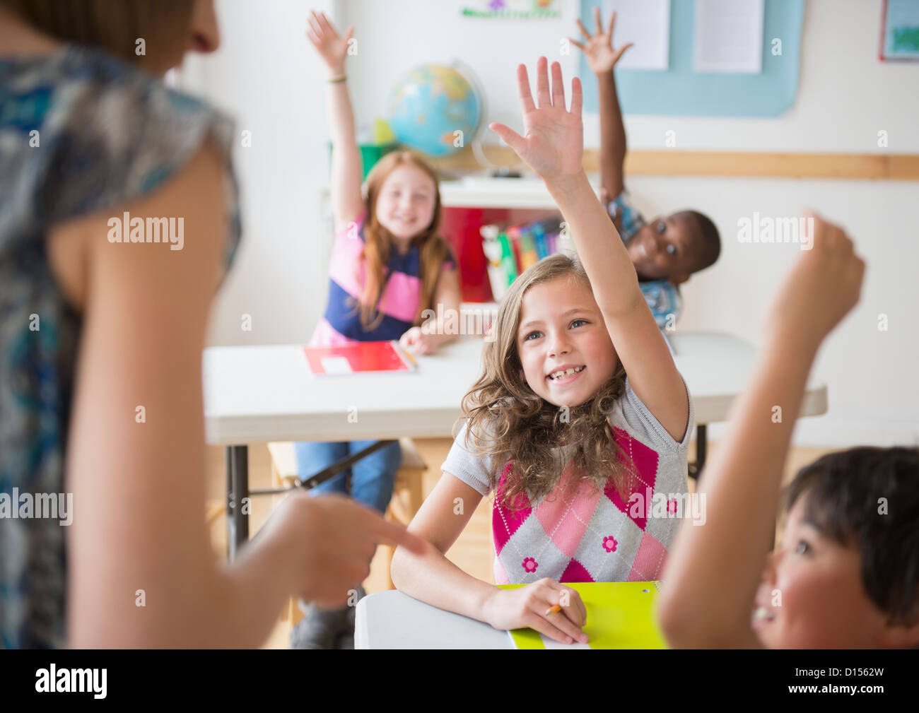 USA, New Jersey, Jersey City, Children (8-9) raising hands in classroom ...