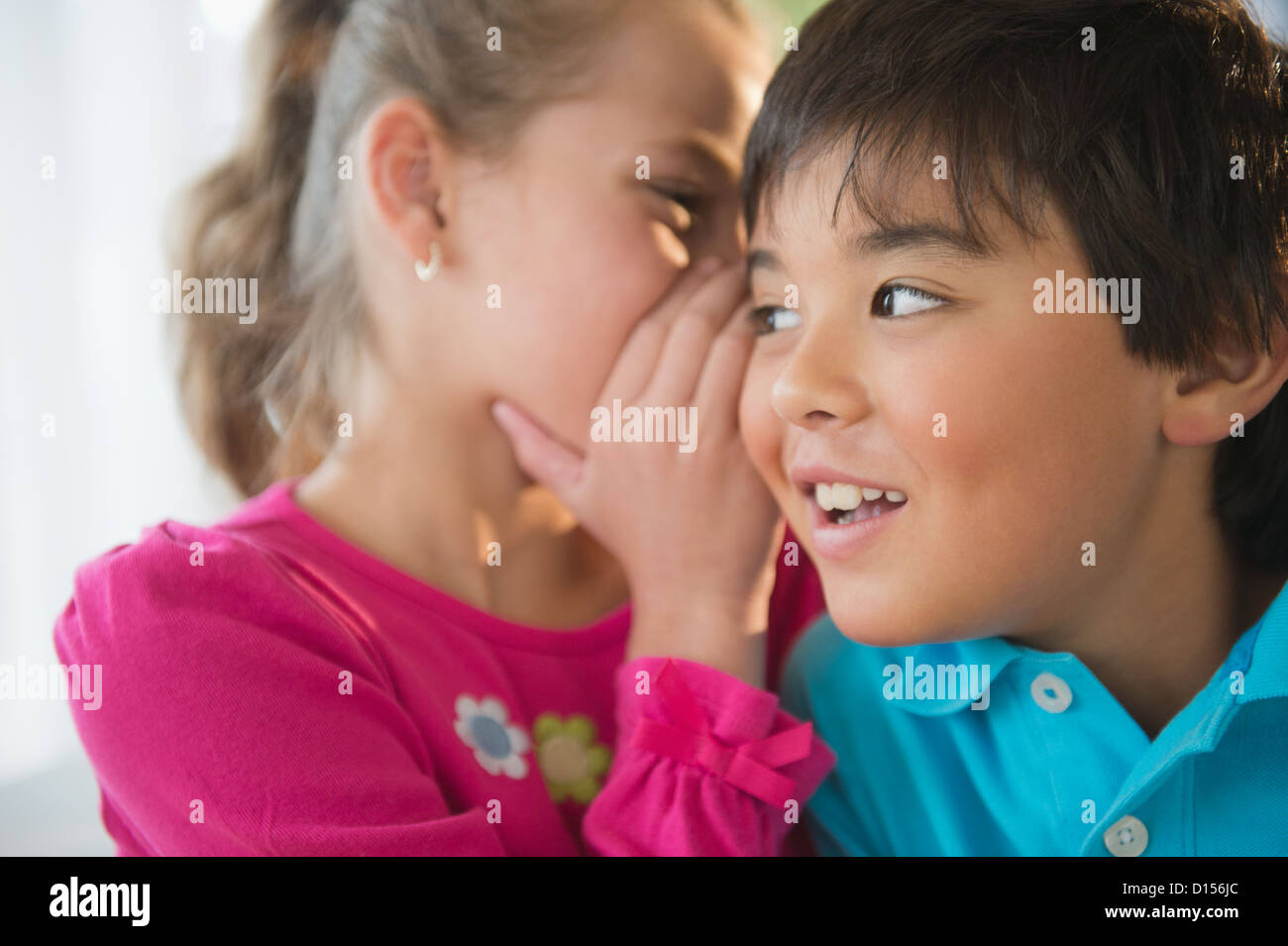 Girl whispering into boys ear hi-res stock photography and images - Alamy
