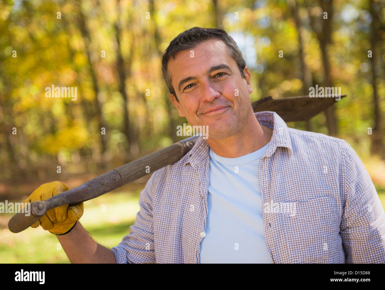USA, New Jersey, Mendham, Portrait of smiling man holding shovel ...