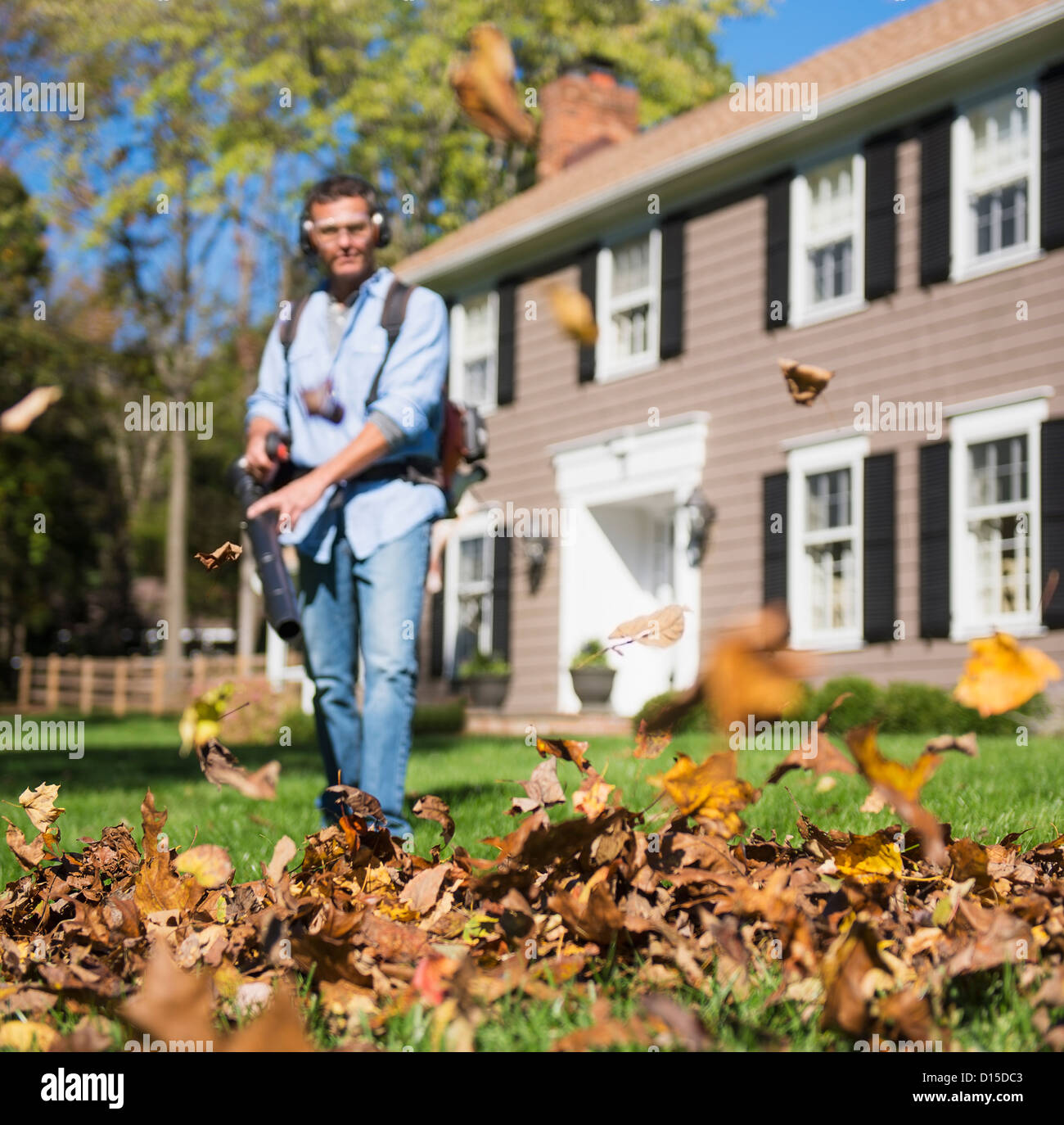 USA, New Jersey, Mendham, Man using leaf blower in front yard Stock ...
