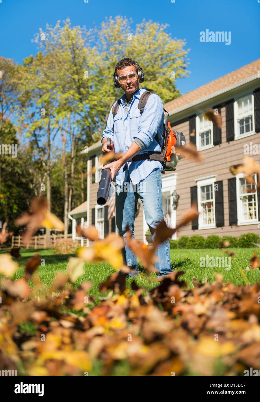 USA, New Jersey, Mendham, Man using leaf blower in front yard Stock ...