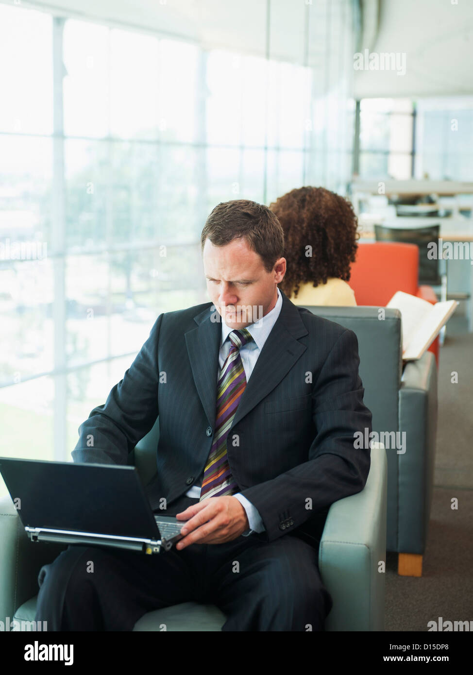 USA, Utah, Salt Lake City, Man using laptop while waiting in lobby ...