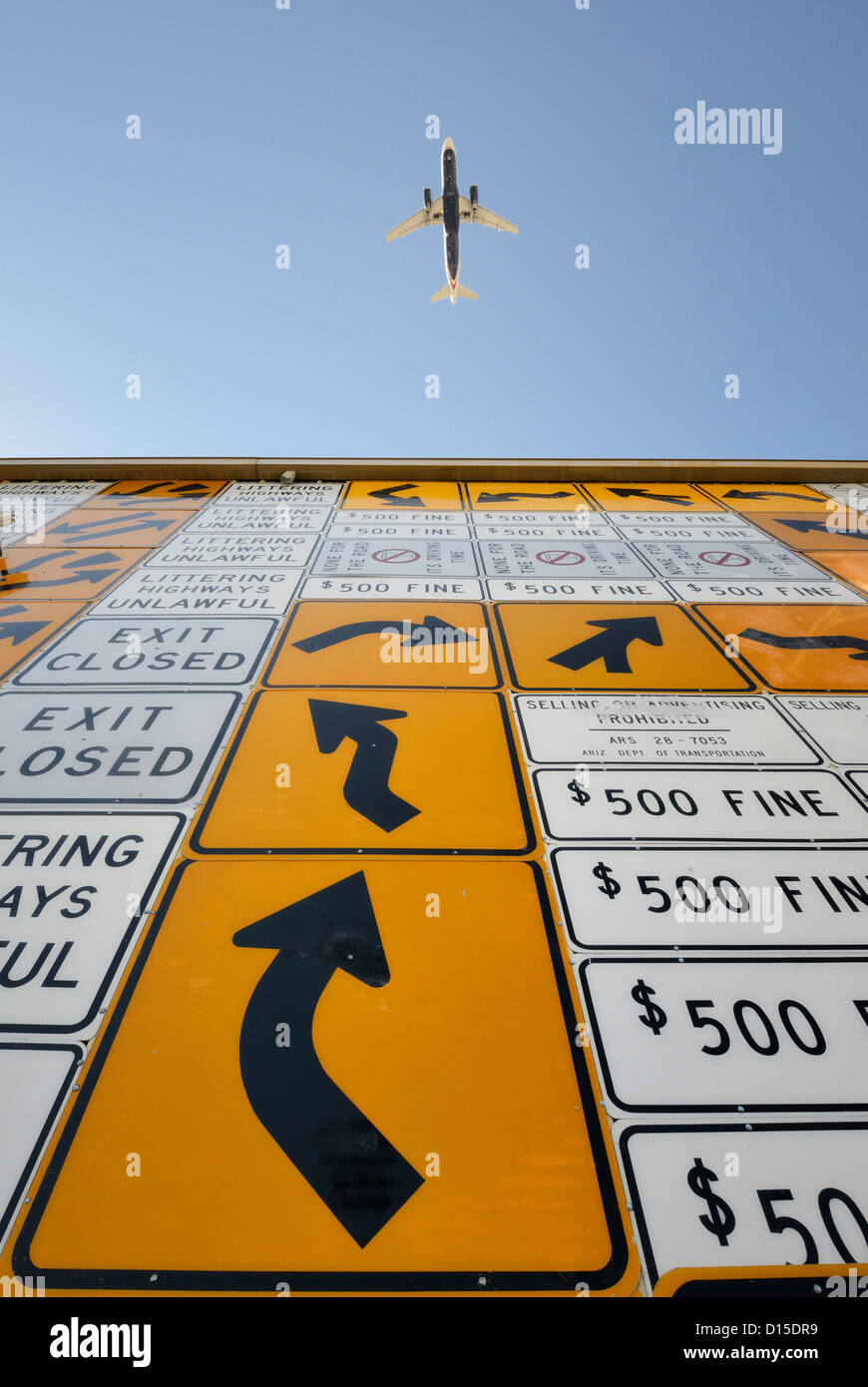Mural of road signs with a commercial aircraft overhead Stock Photo - Alamy