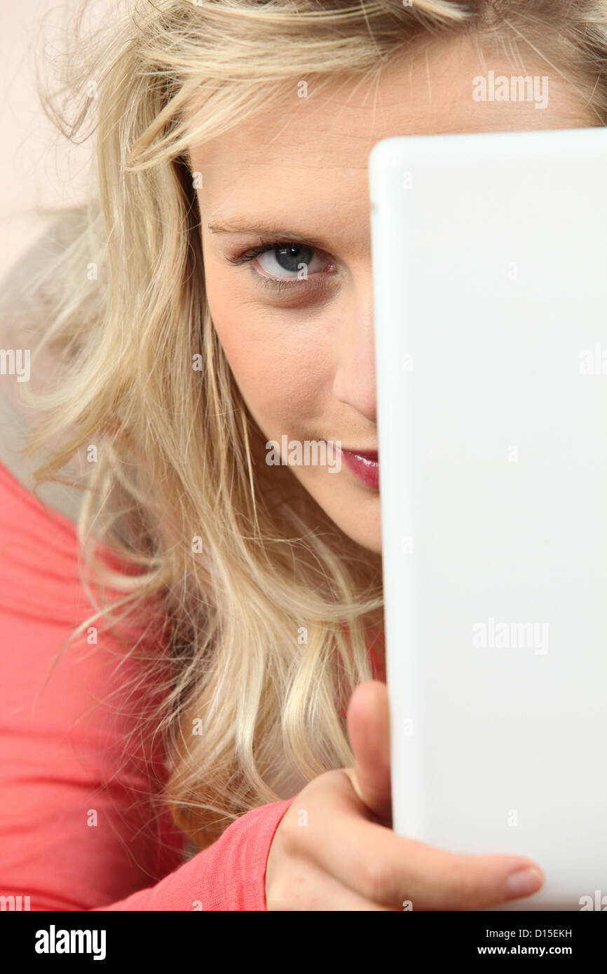 Blond hiding face behind laptop Stock Photo - Alamy