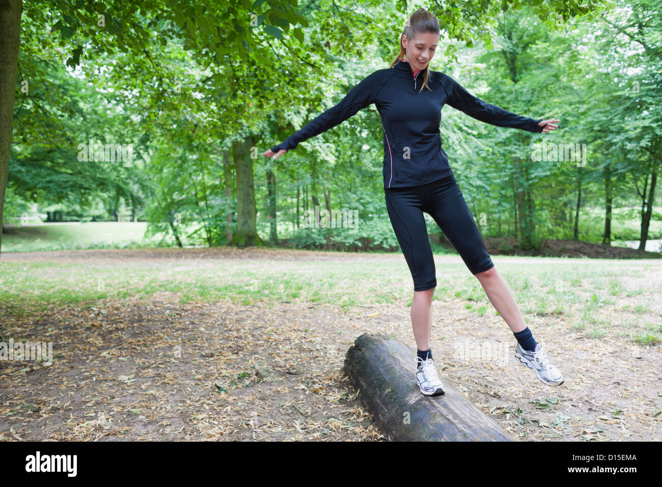 Young woman balancing on log Stock Photo - Alamy