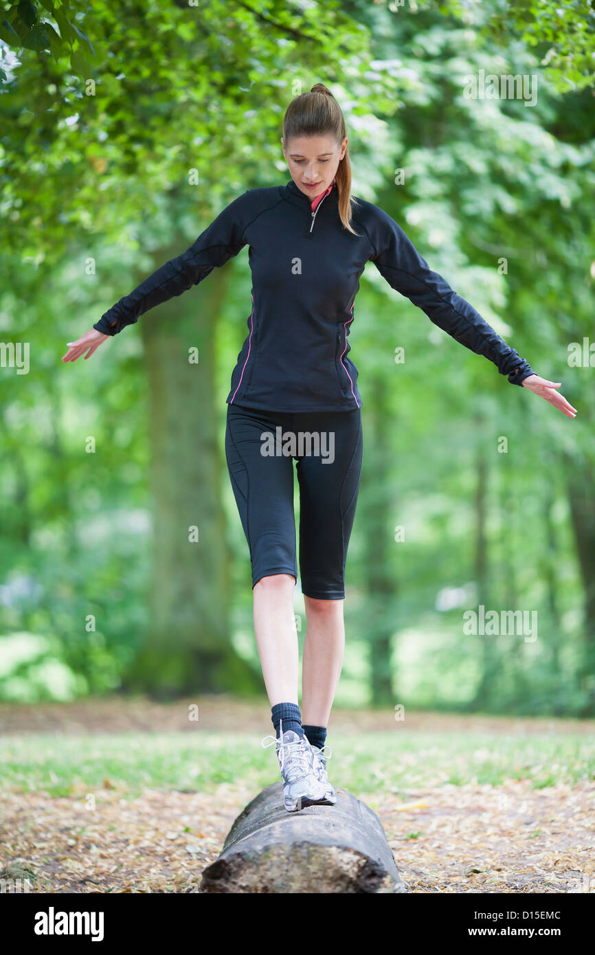 Young woman balancing on log Stock Photo - Alamy