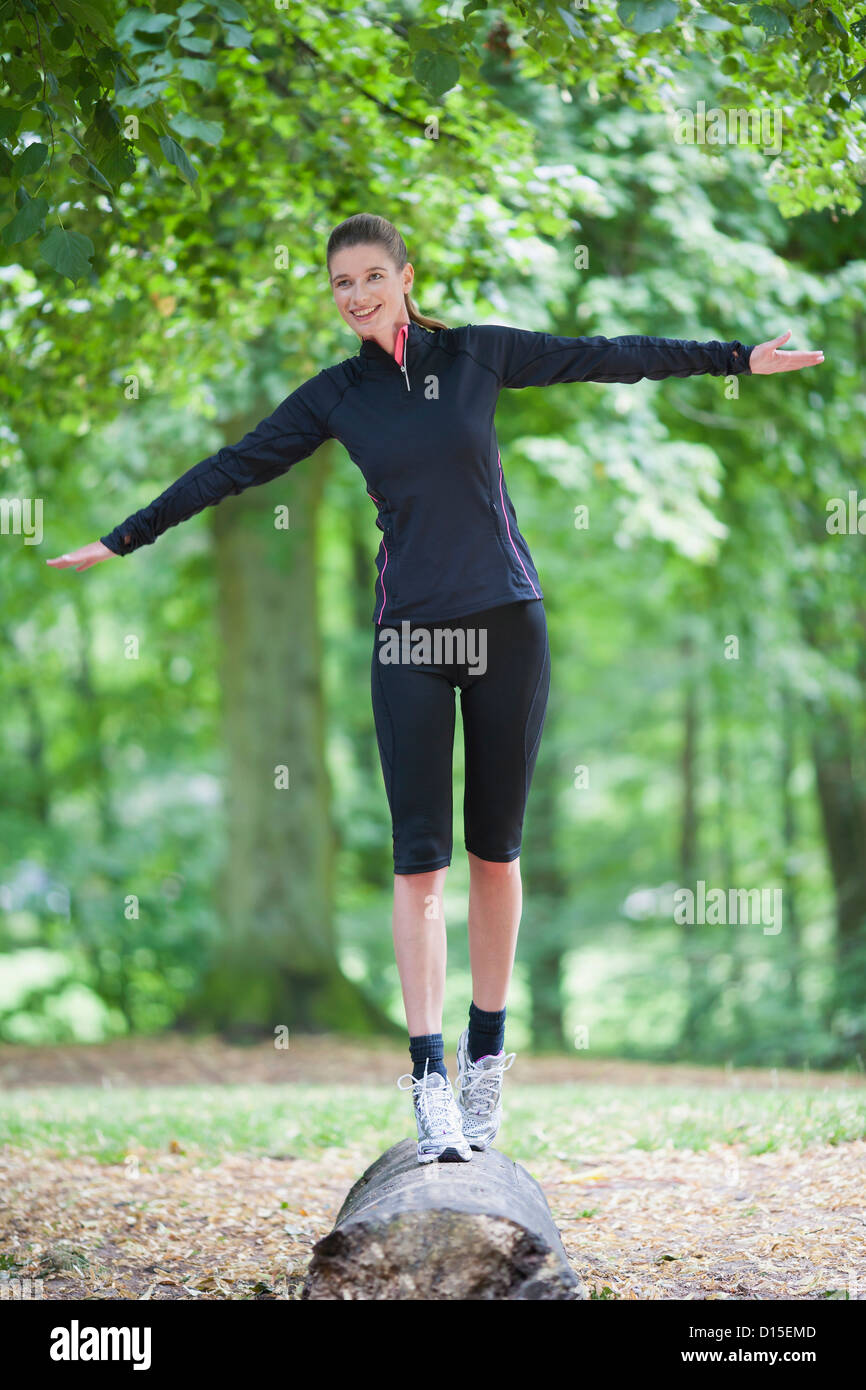 Young woman balancing on log Stock Photo - Alamy