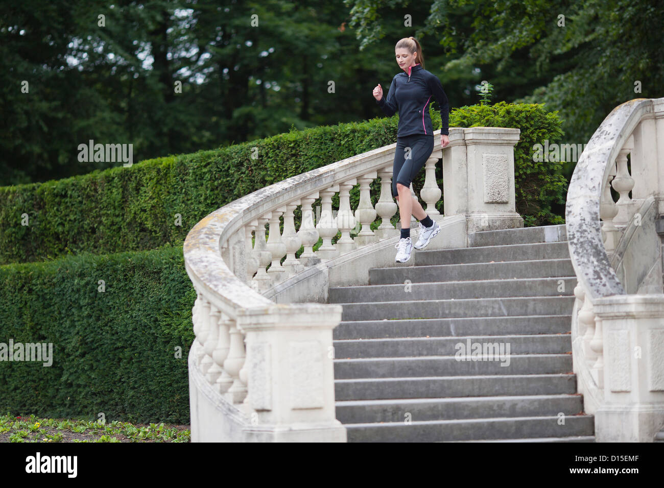 Young woman running down stairs Stock Photo - Alamy